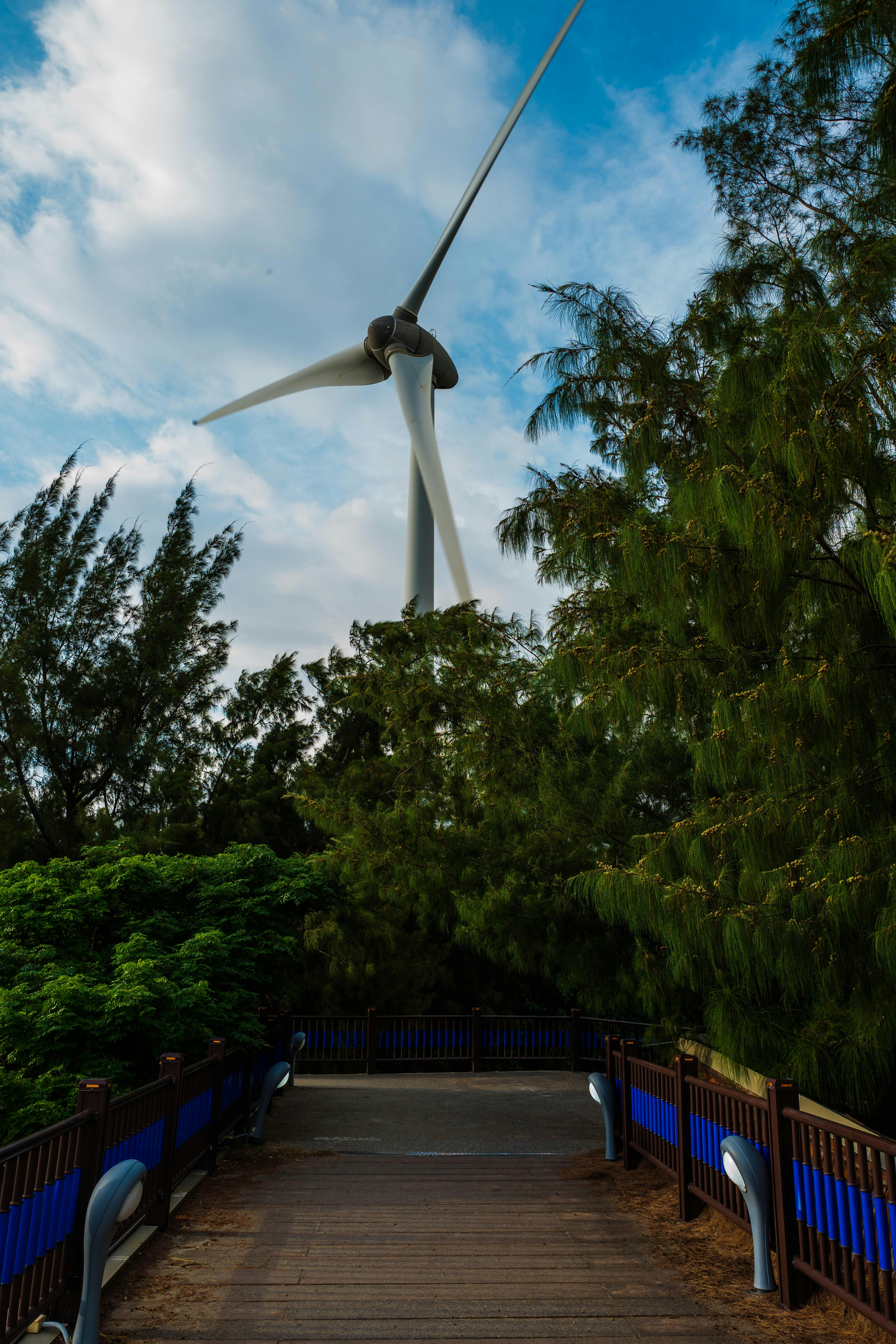 A bridge with a wind turbine in the background photo – Free Tree Image ...
