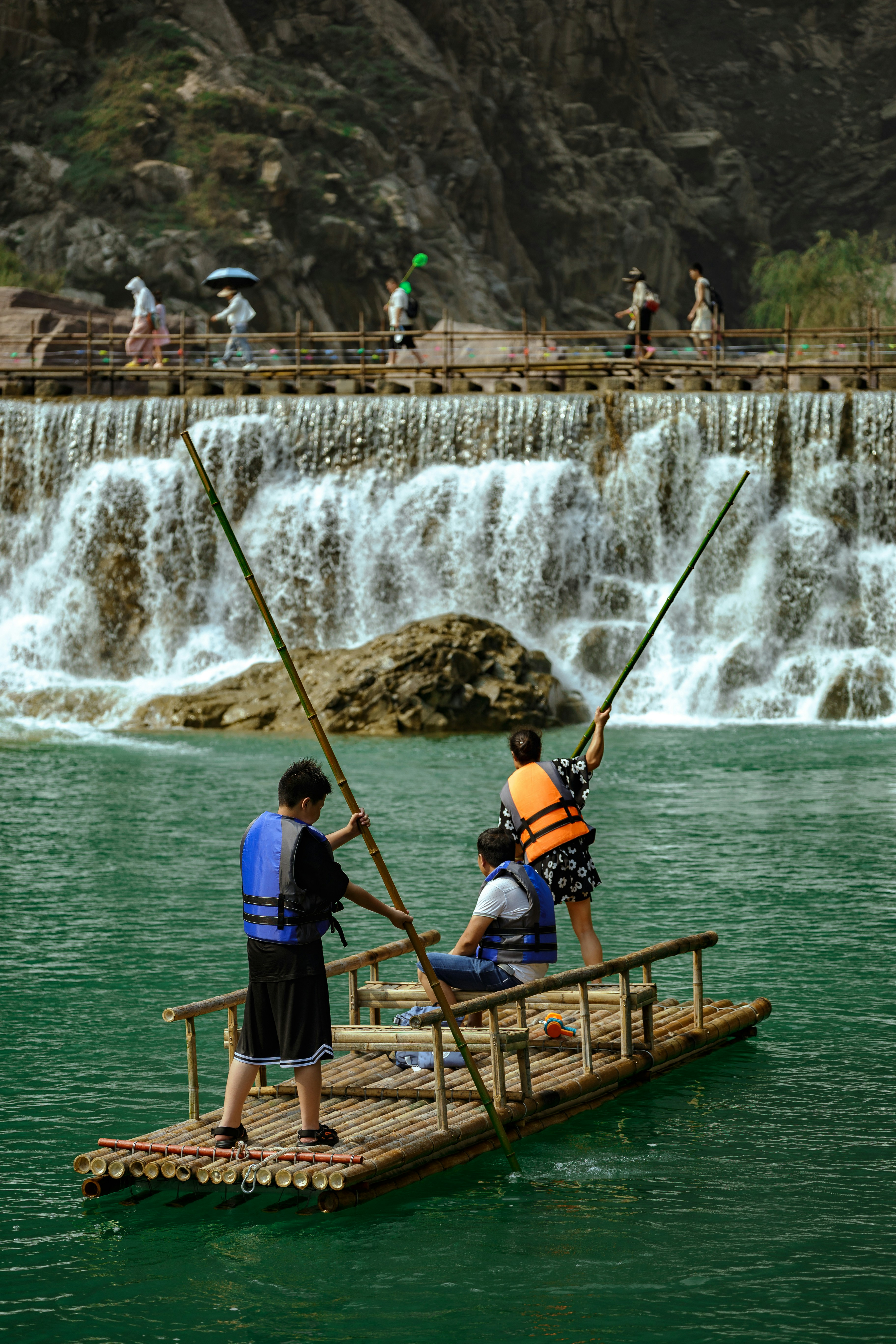 A group of people standing on a raft in the water photo – Free ...