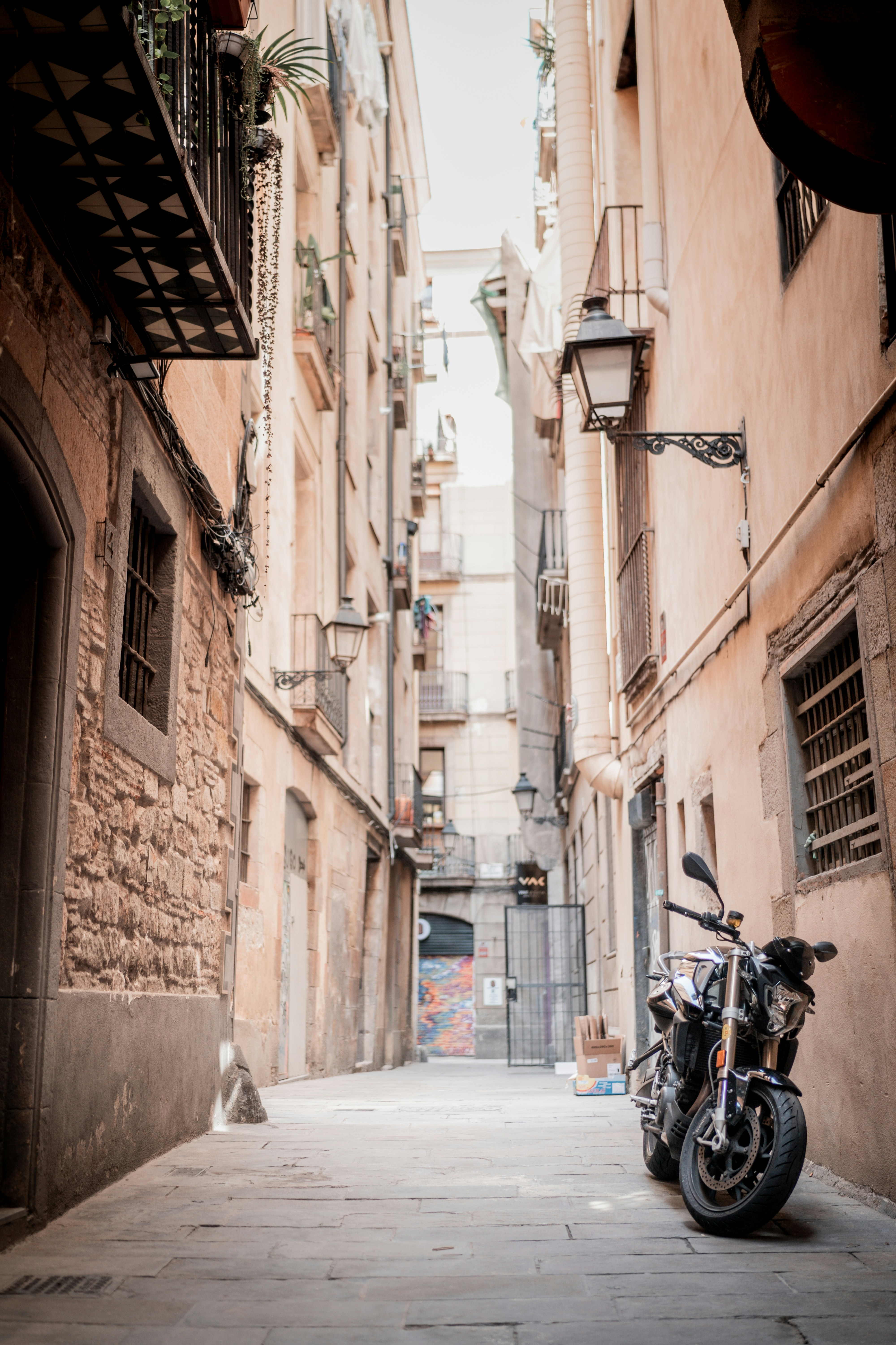 A motorcycle is parked in an alley way photo – Free Barcelona Image on ...