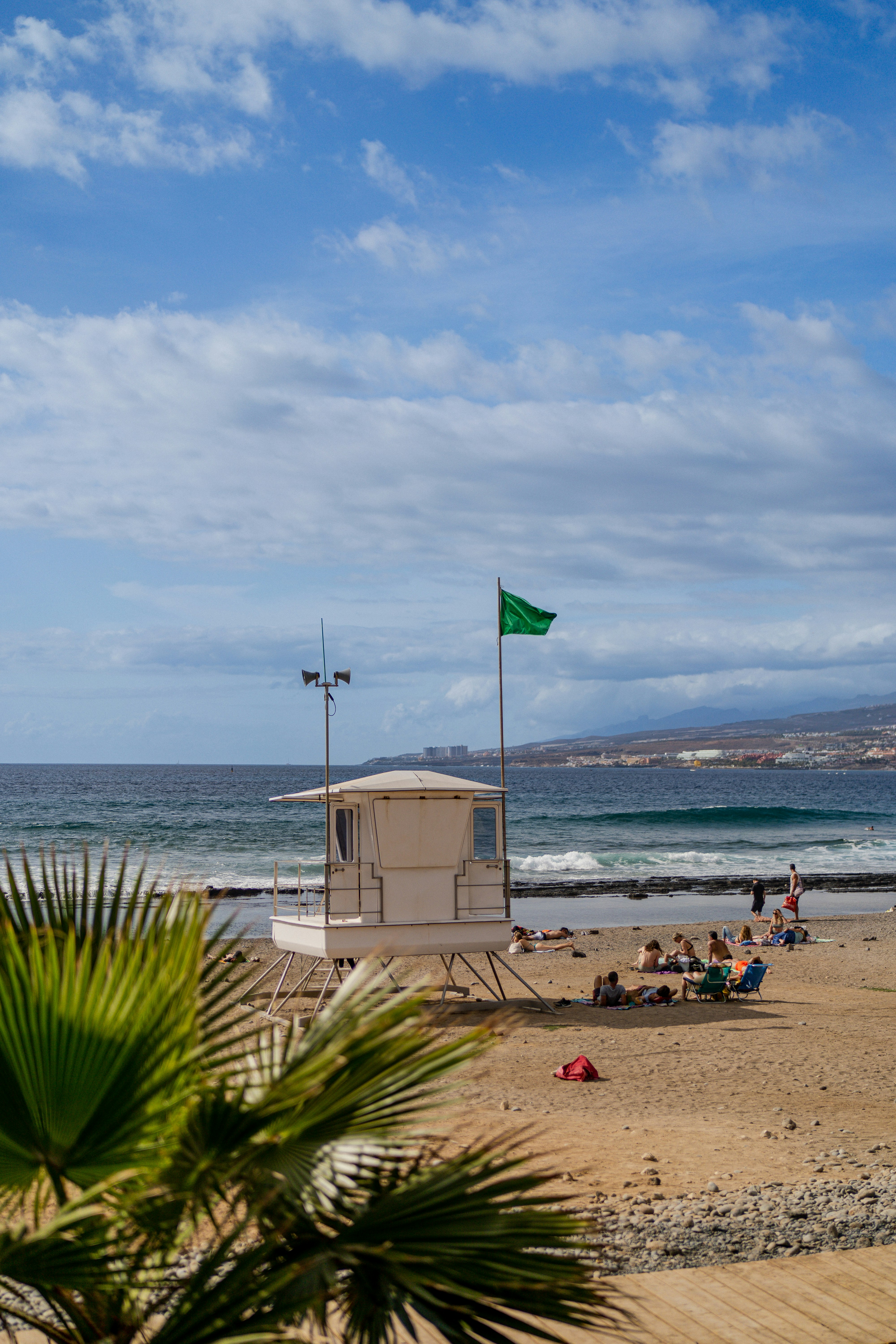 Green-Flag Lifeguard Tower Framing a Beach Day by the Sea