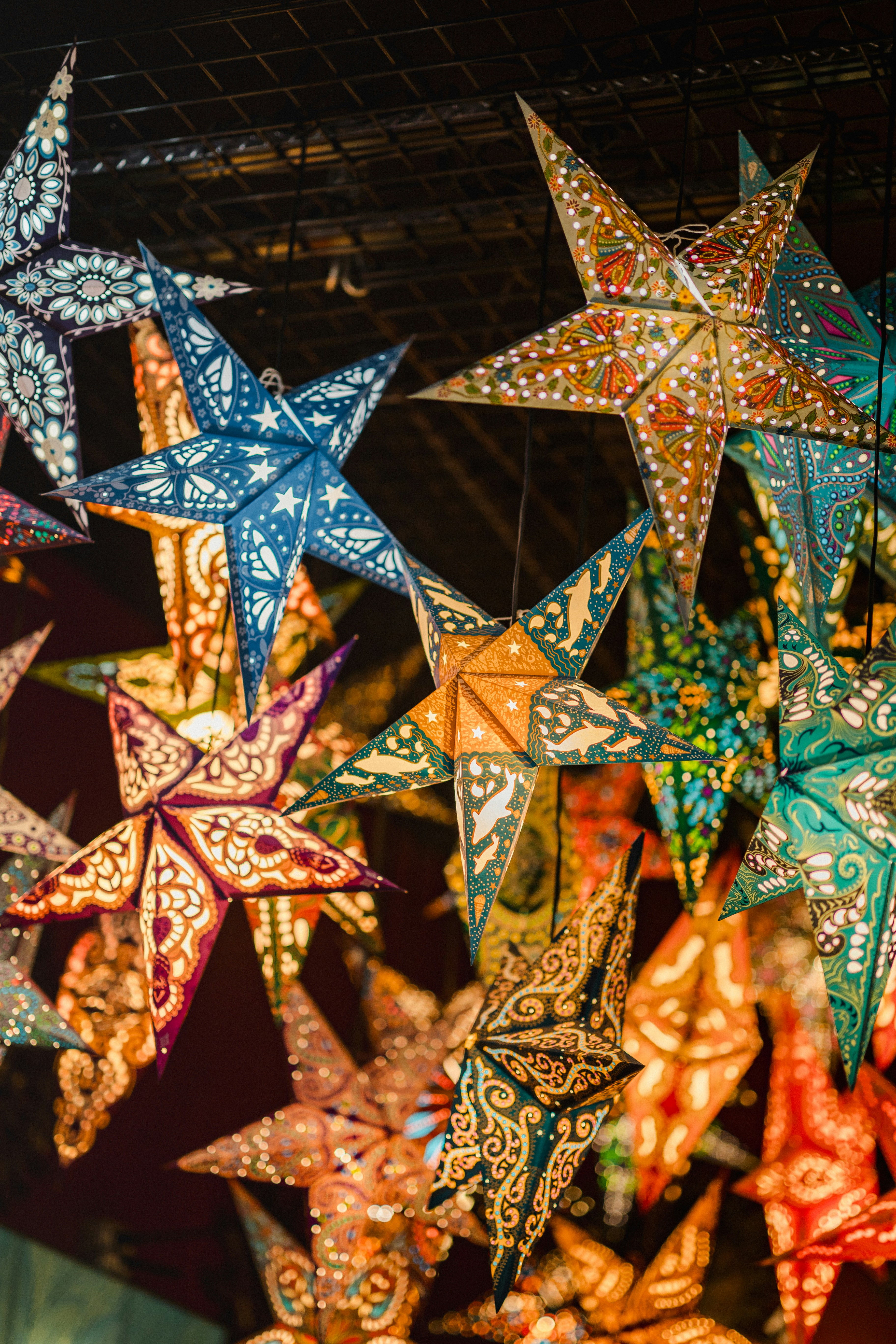 A bunch of colorful paper stars hanging from a ceiling photo – Free ...