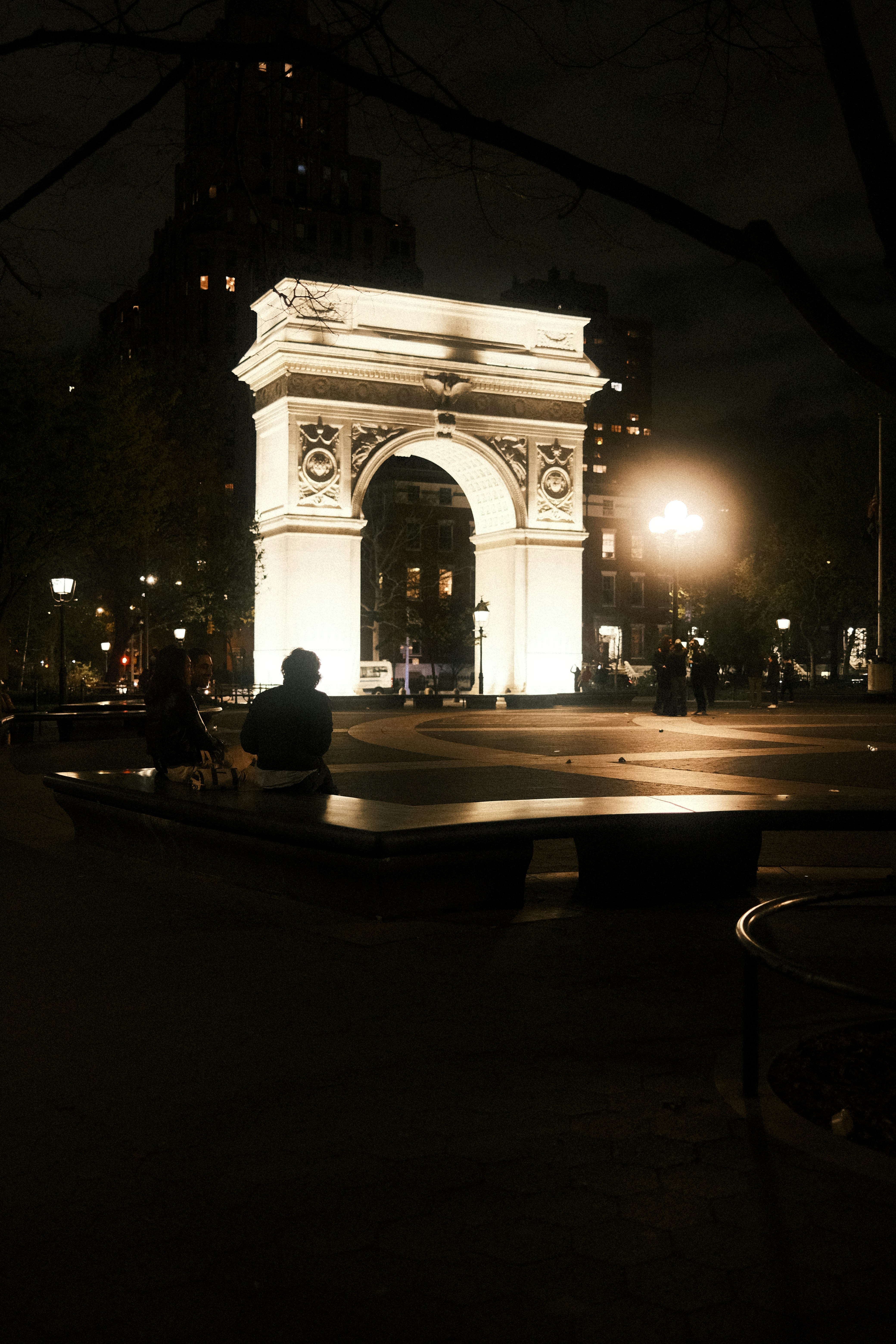 Night Archway in Glow: A Quiet Moment by the Monument
