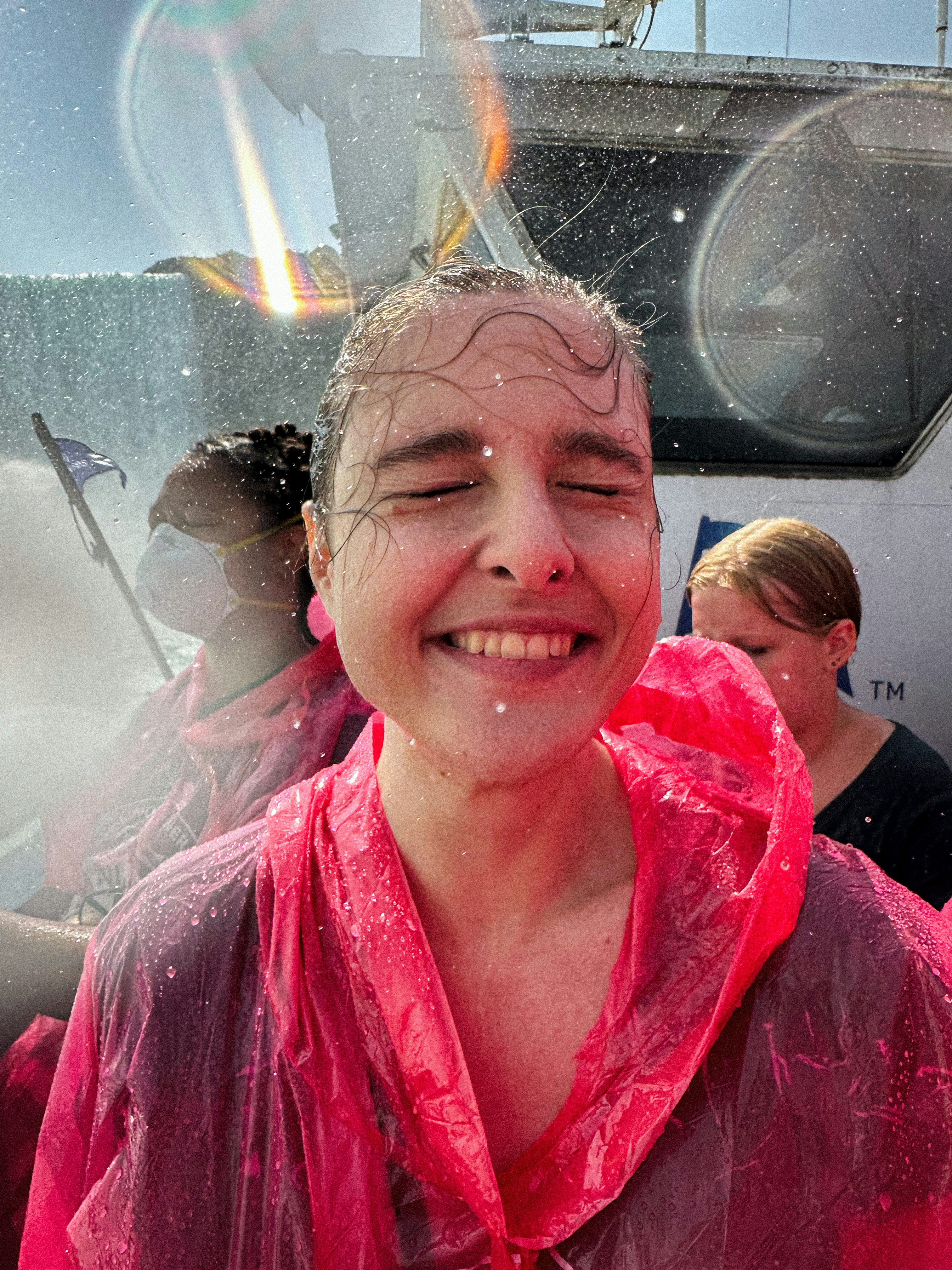 Pleasure in the Spray: A Pink Poncho Moment on a Wind-Swept Boat
