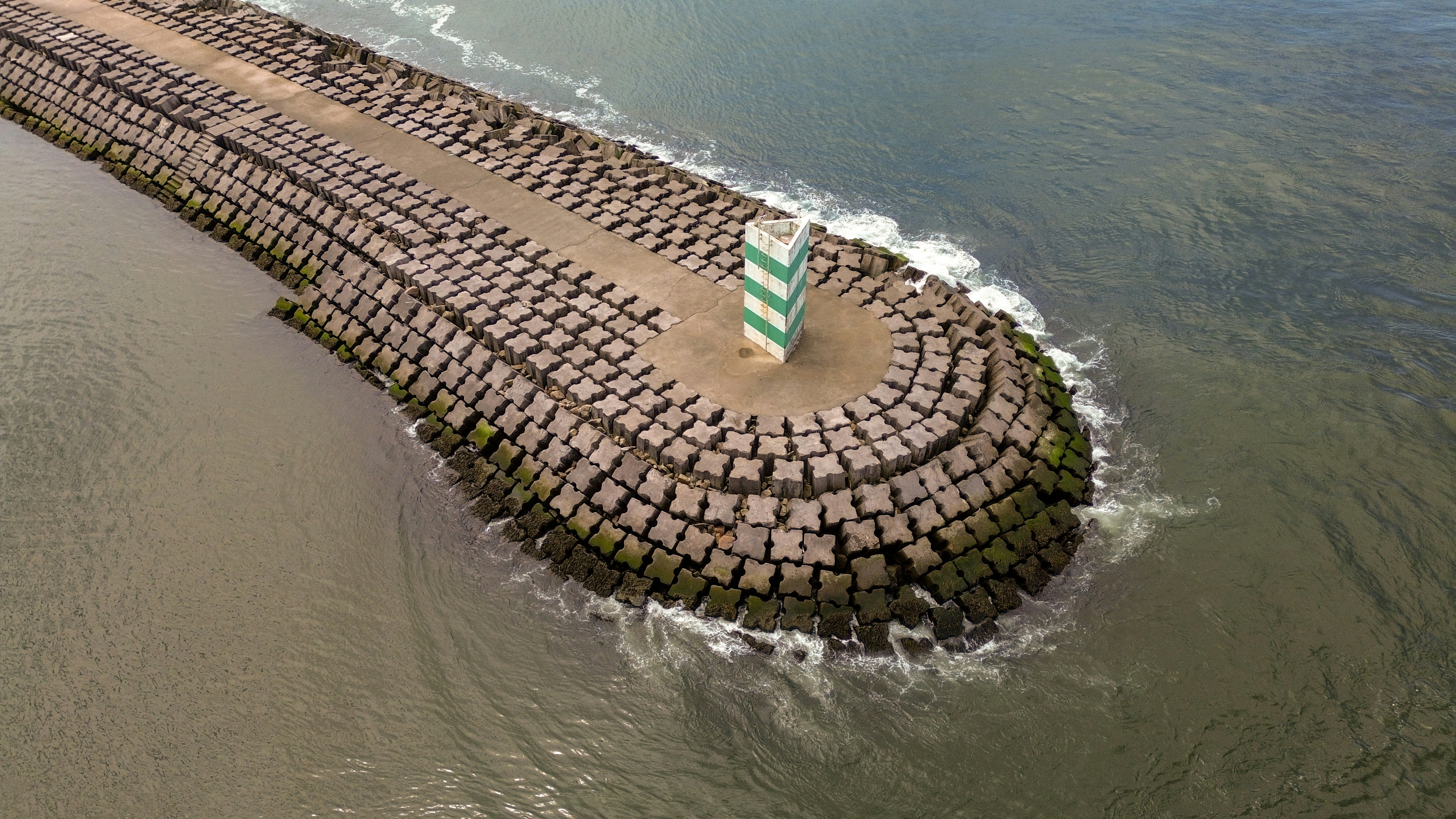 Circular Breakwater Beacon: Aerial Pause at the Sea's Edge