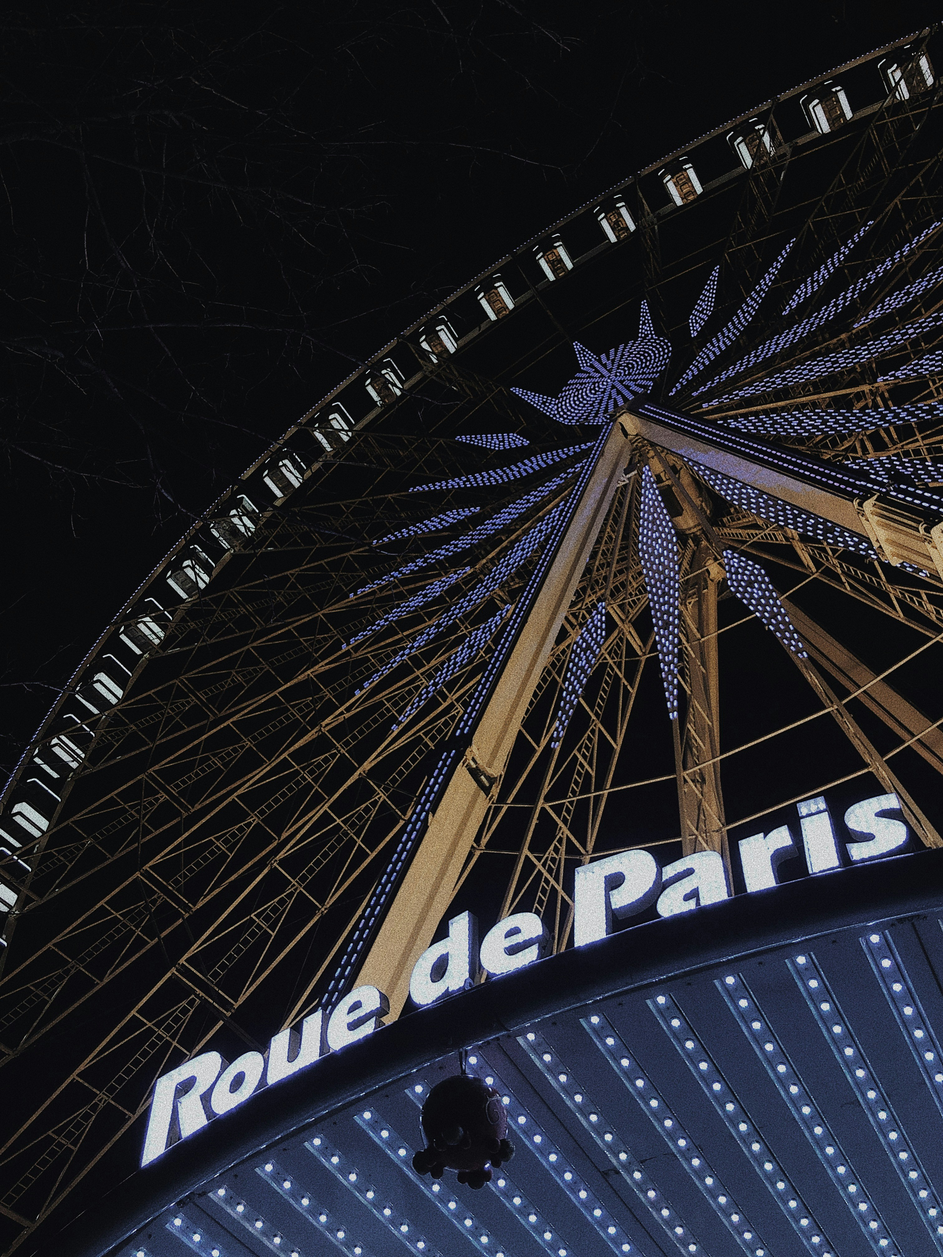 Neon Starburst Over a Tilted Paris Ferris Wheel