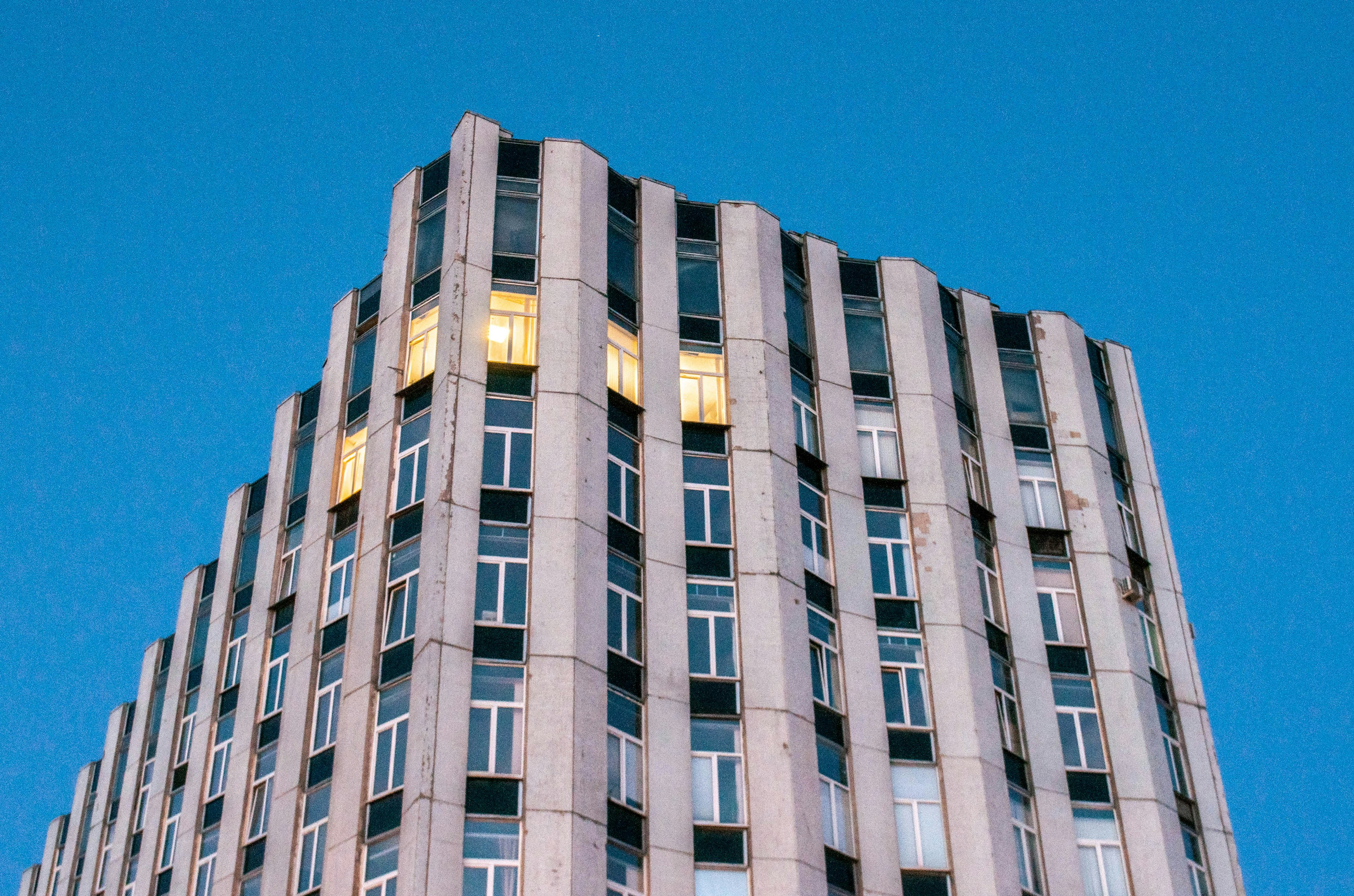 Tower Facade in Perspective: A Grid of Light and Concrete Against the Sky
