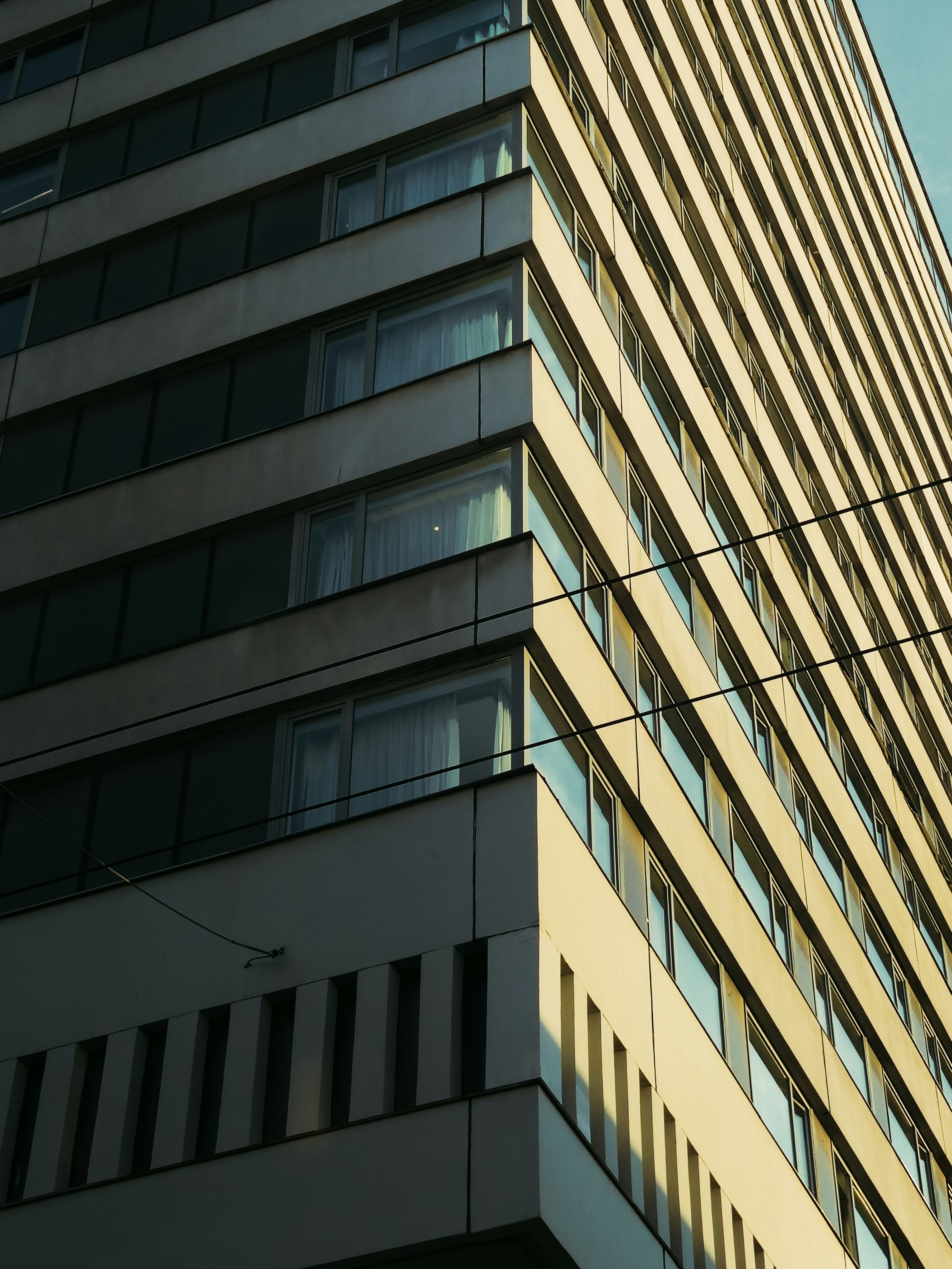Foto Un edificio alto con muchas ventanas al lado de un semáforo – Imagen Edificio de oficinas ...