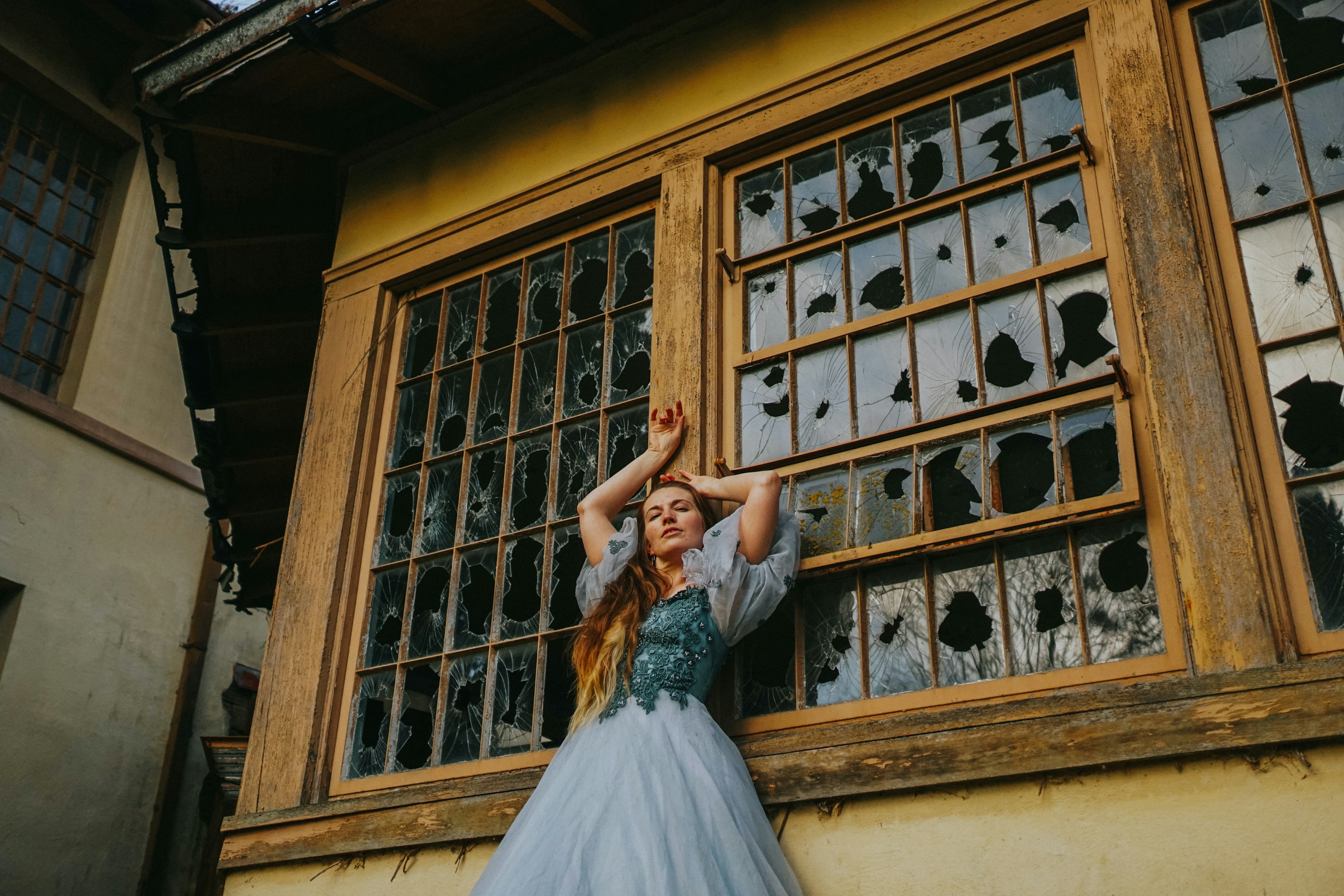 A woman in a blue dress standing in front of a window photo – Free ...