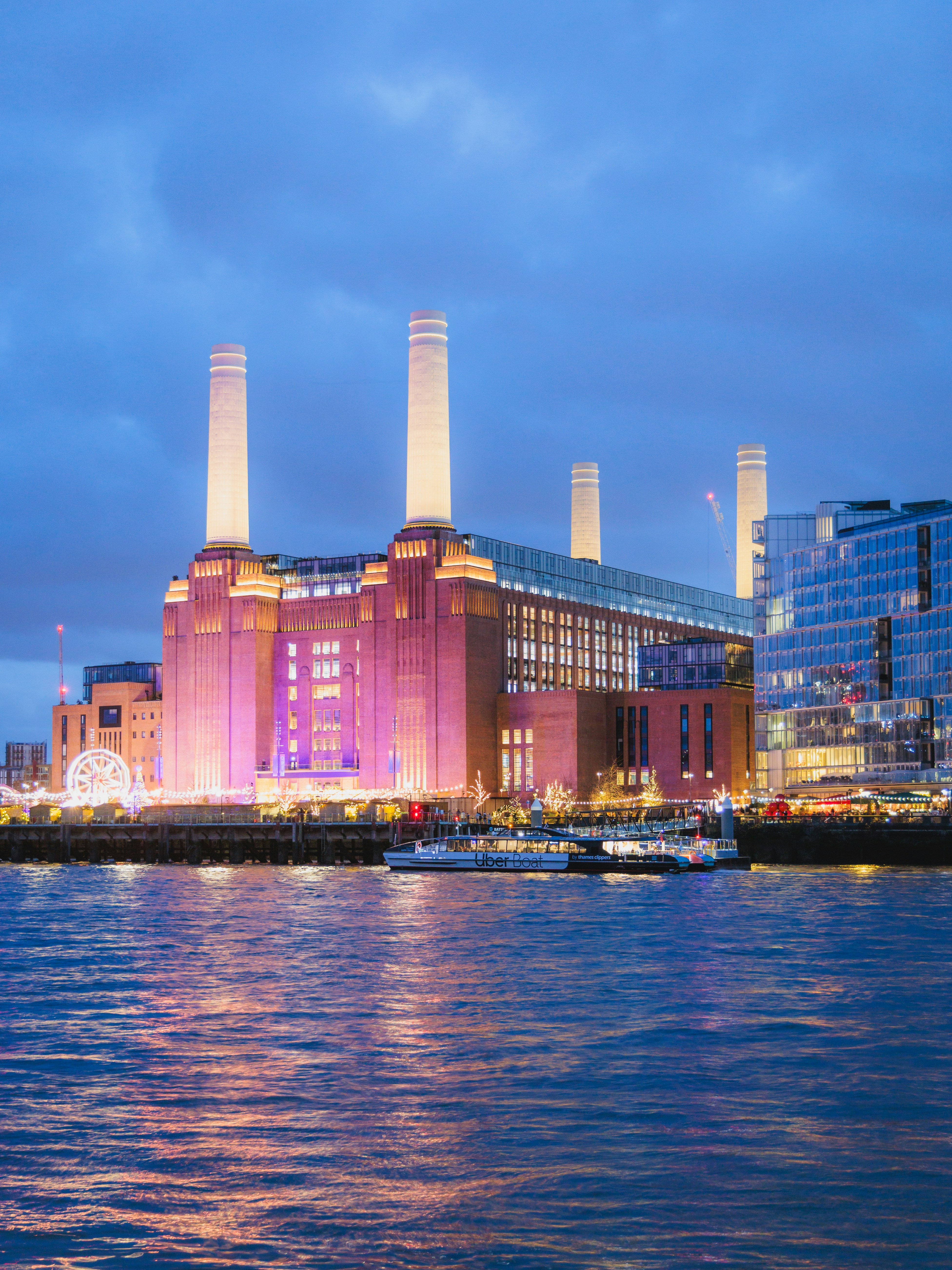 A large factory building sitting next to a body of water photo – Free ...