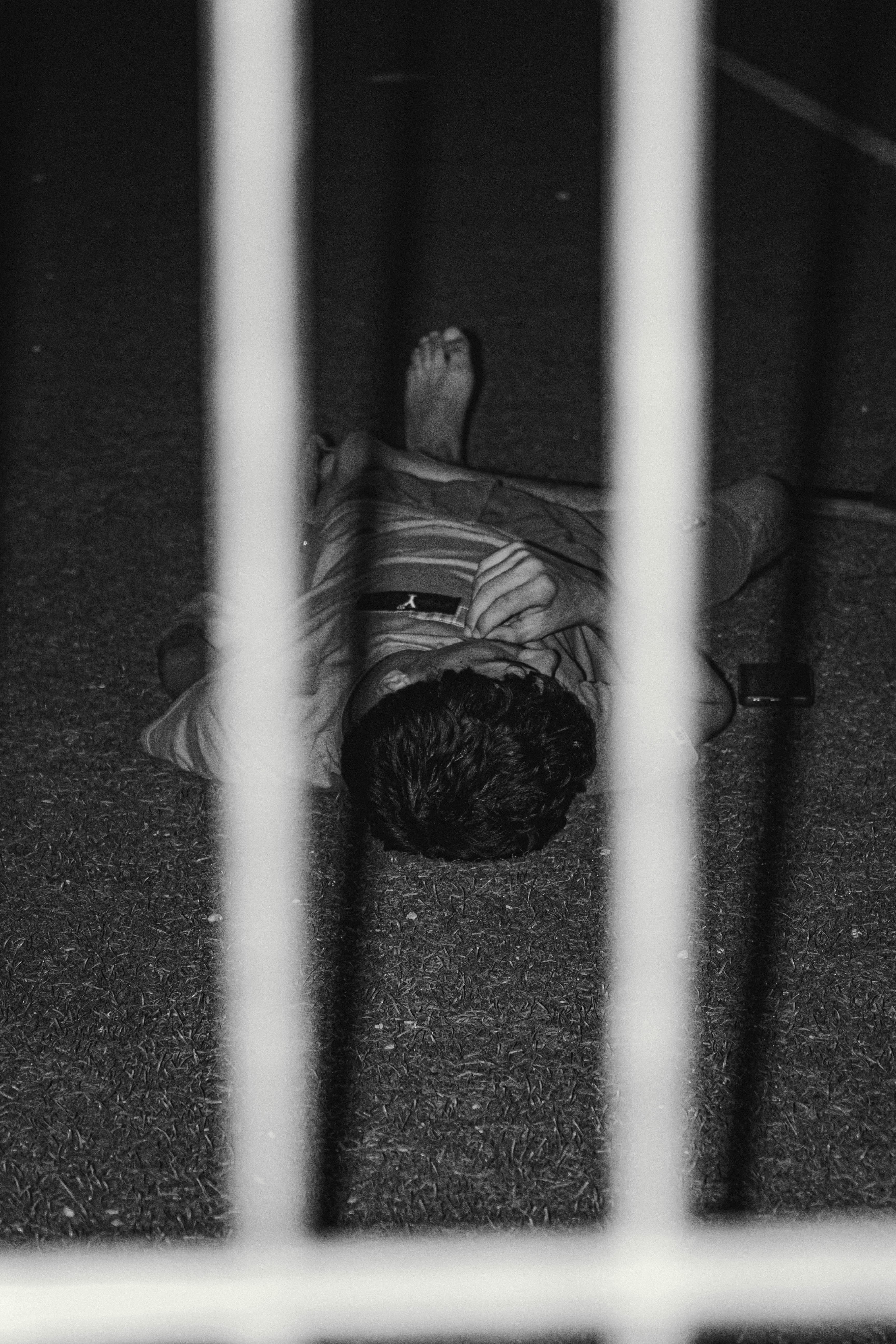Between Iron Rails and Night: A Quiet Figure on the Street