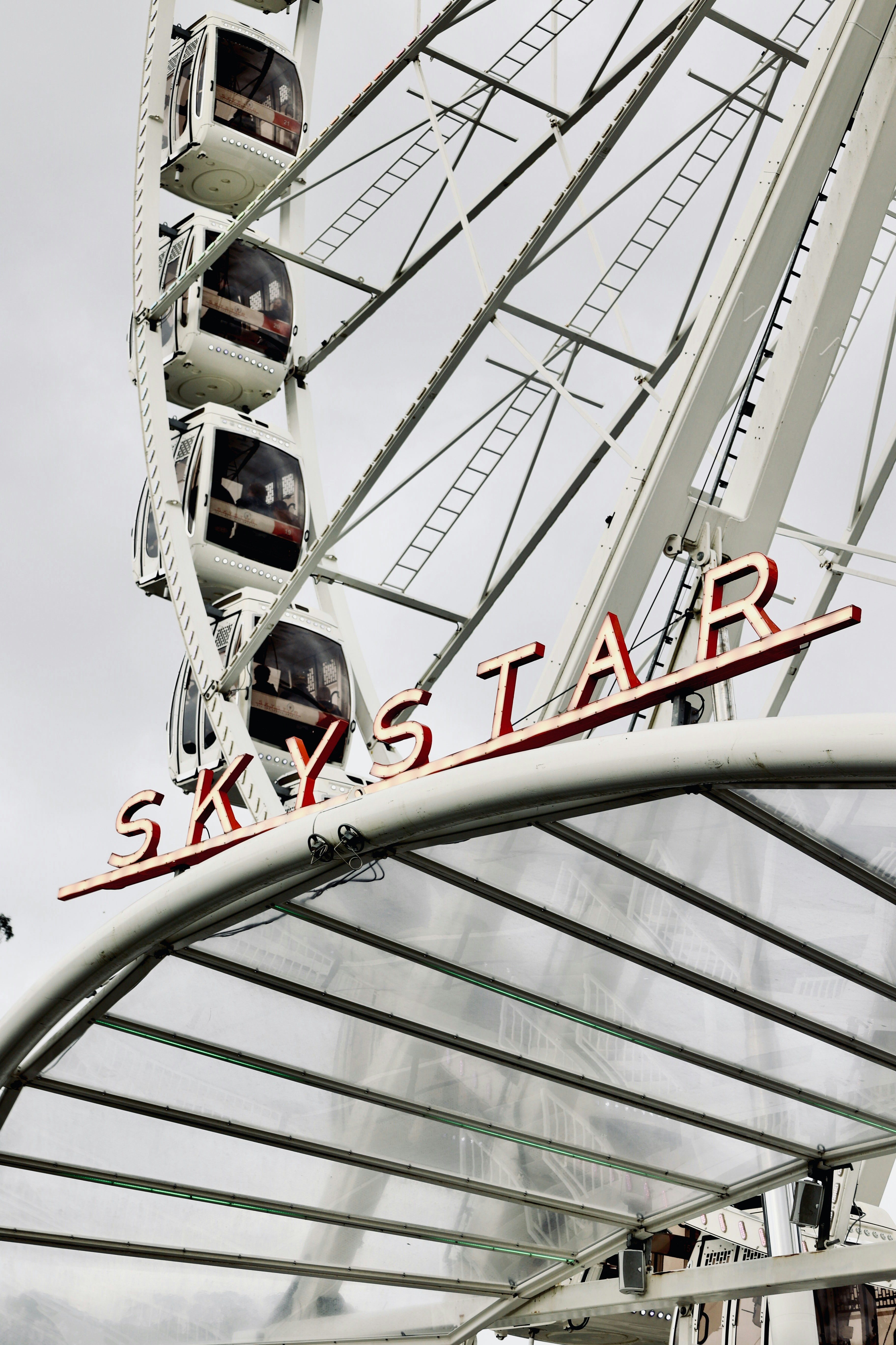 Sky Star Ferris Wheel: Red Letters Framing a Glass-Cabined Arc