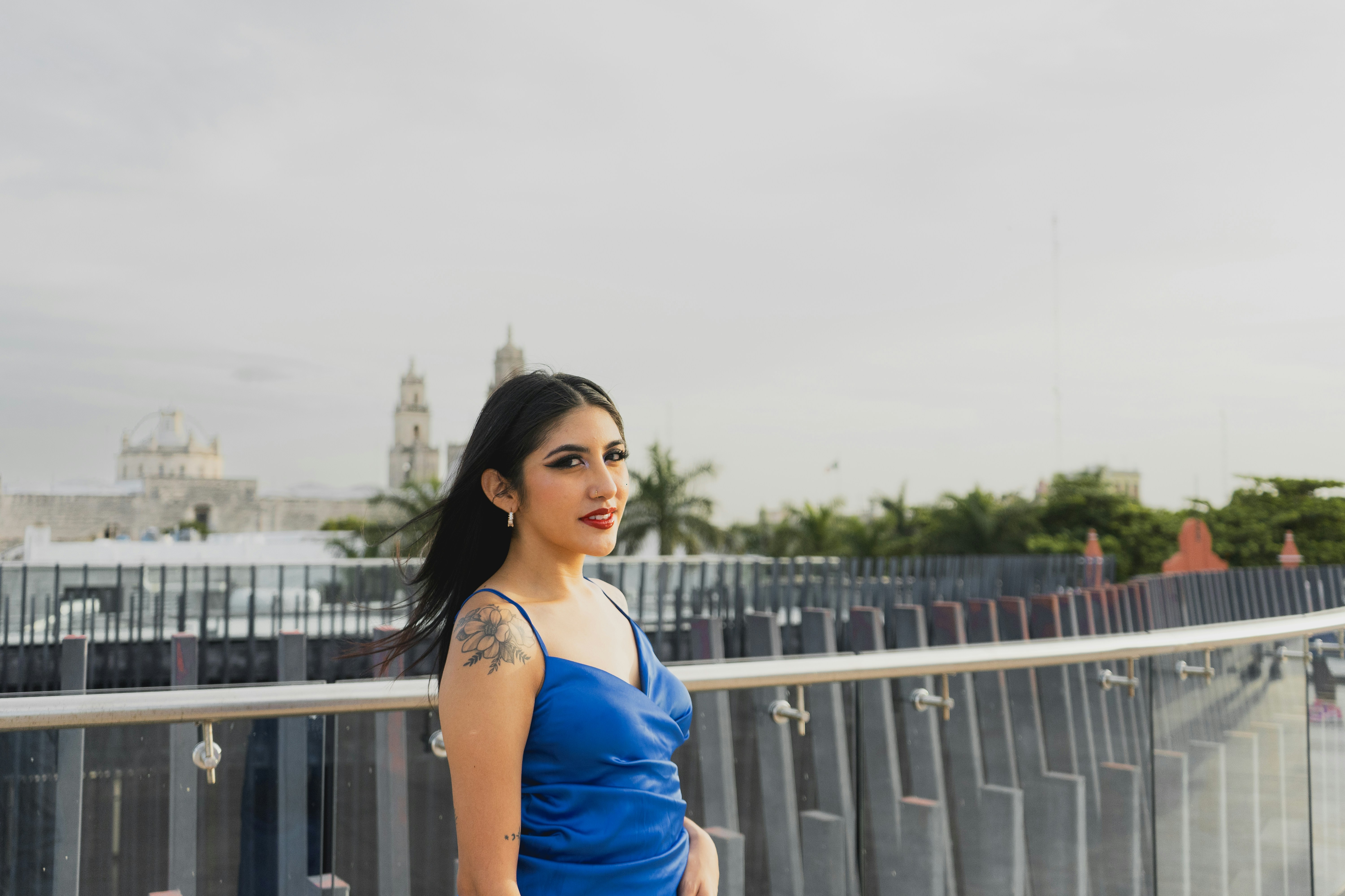 Blue dress, steel rail, and a skyline promise