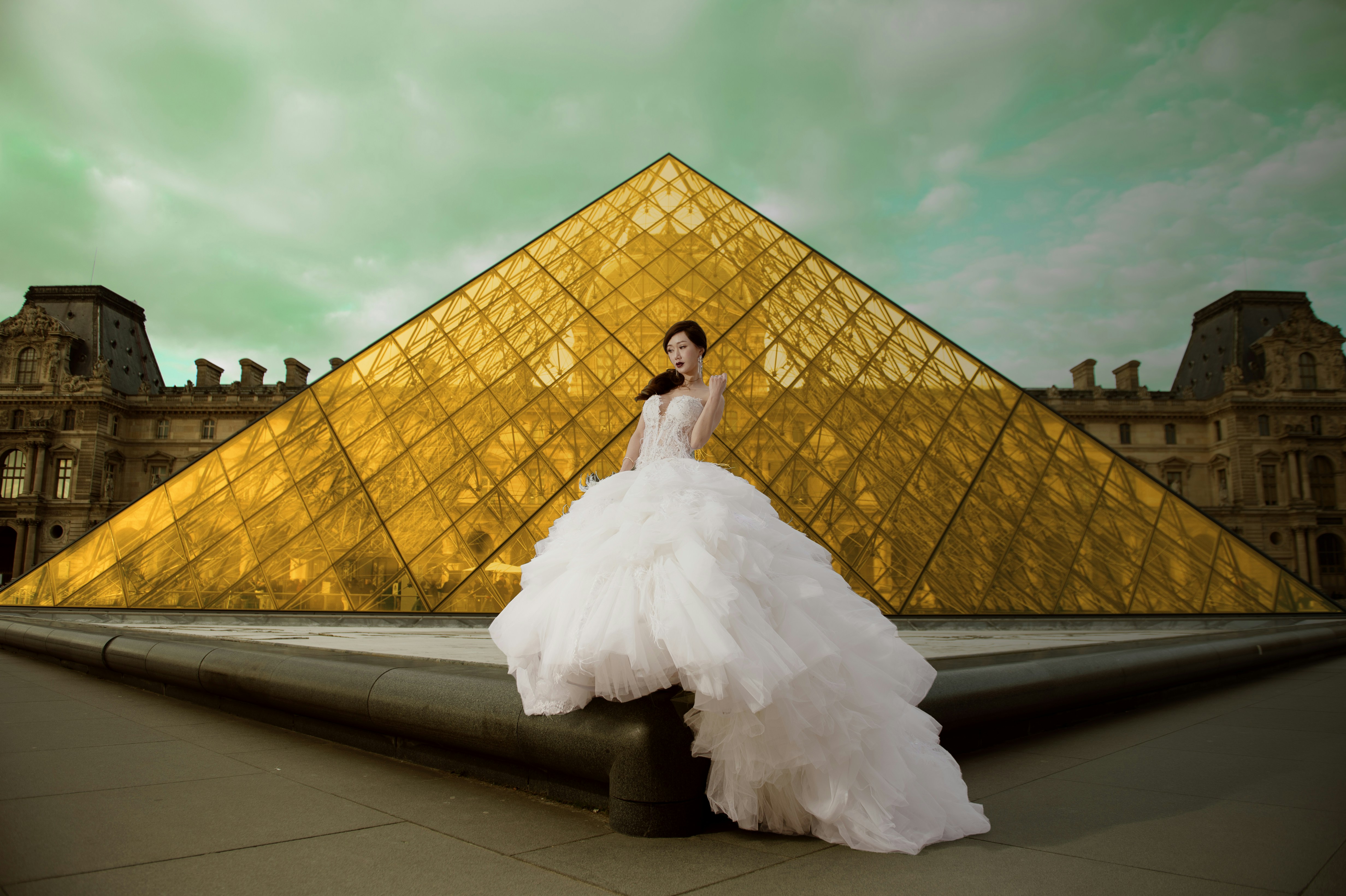 A woman in a white dress standing in front of a pyramid photo – Free ...