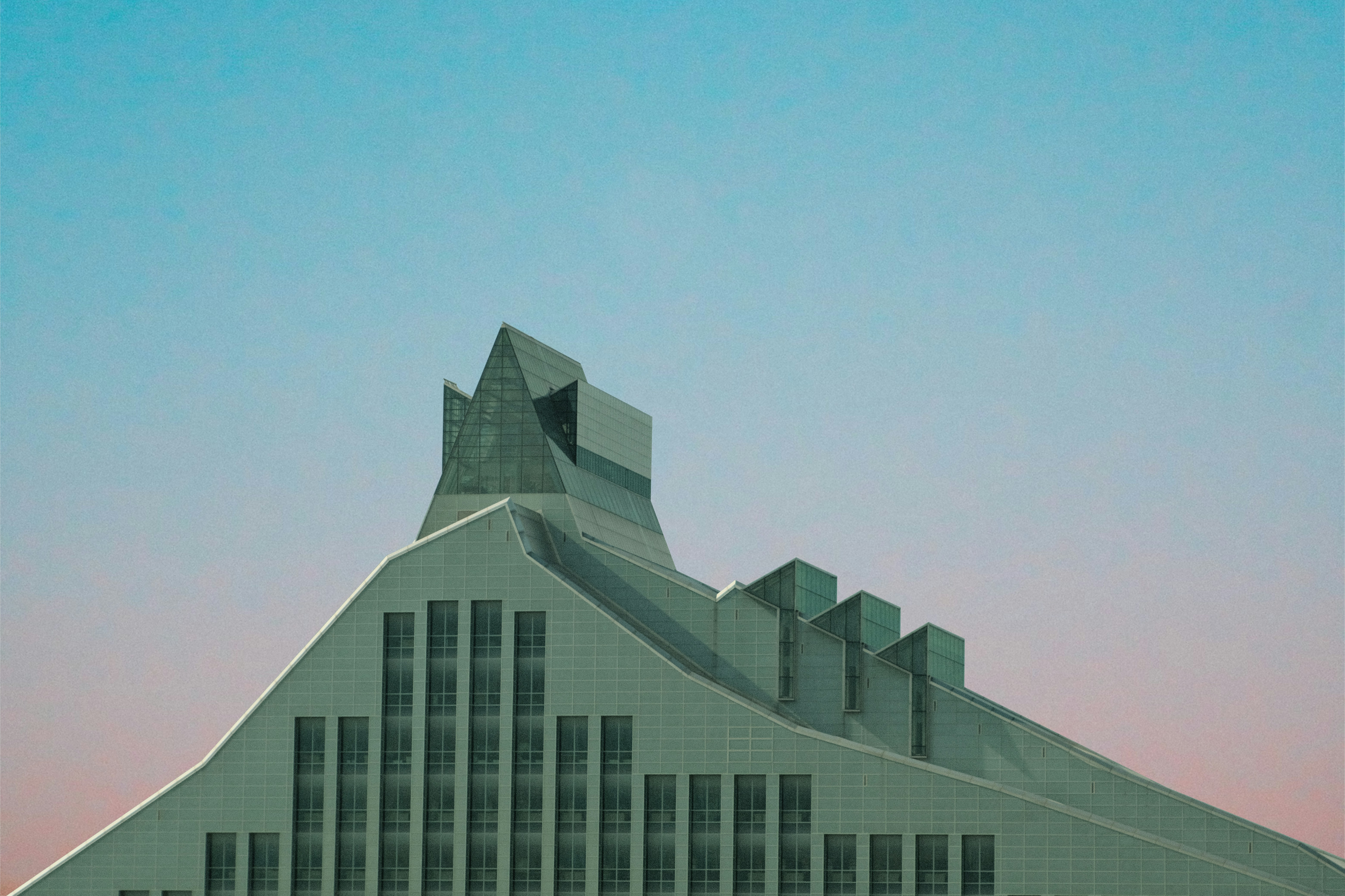 Apexed Facade: Geometric Roof Peaks Beneath a Pastel Dusk