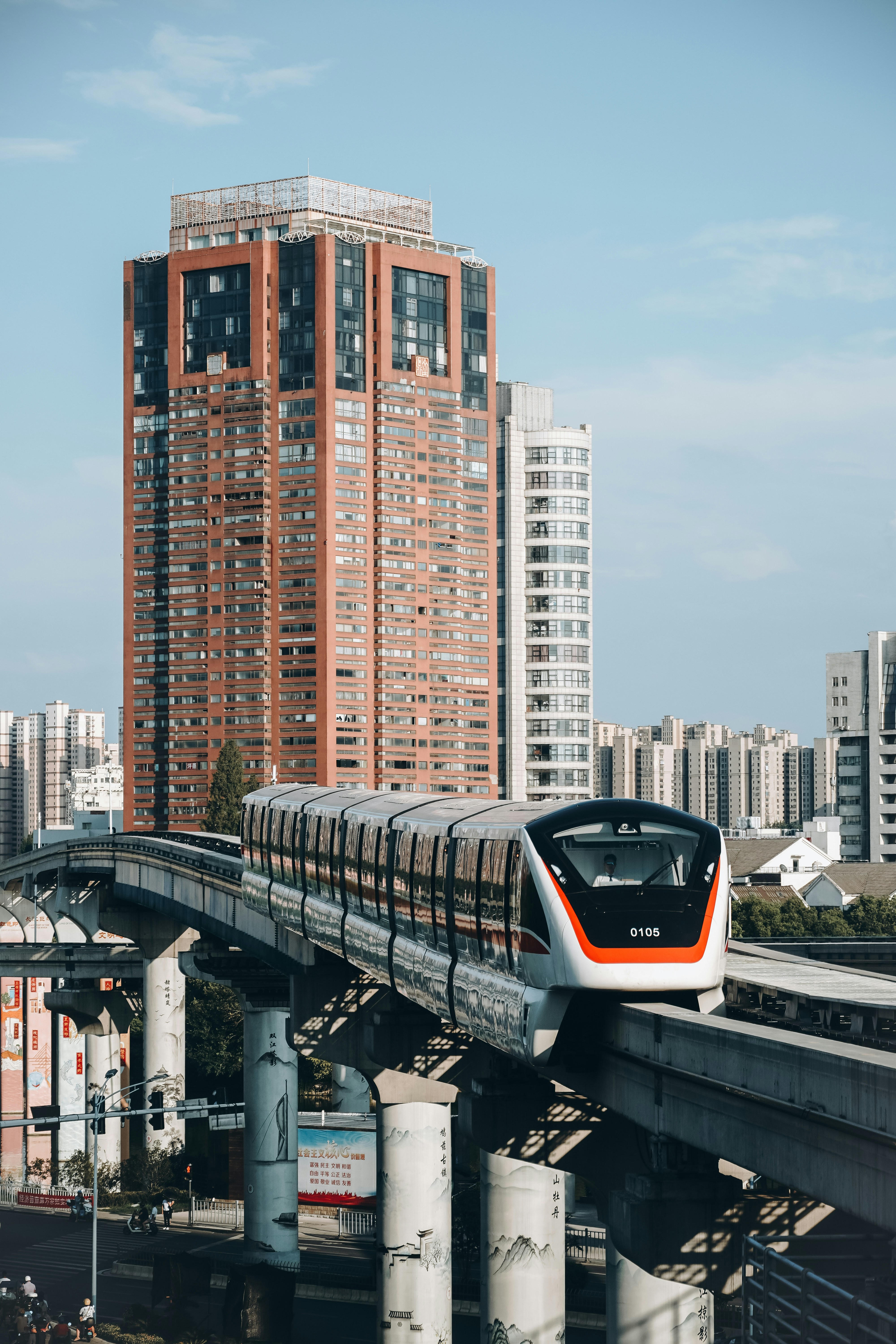 A train traveling over a bridge with tall buildings in the background ...
