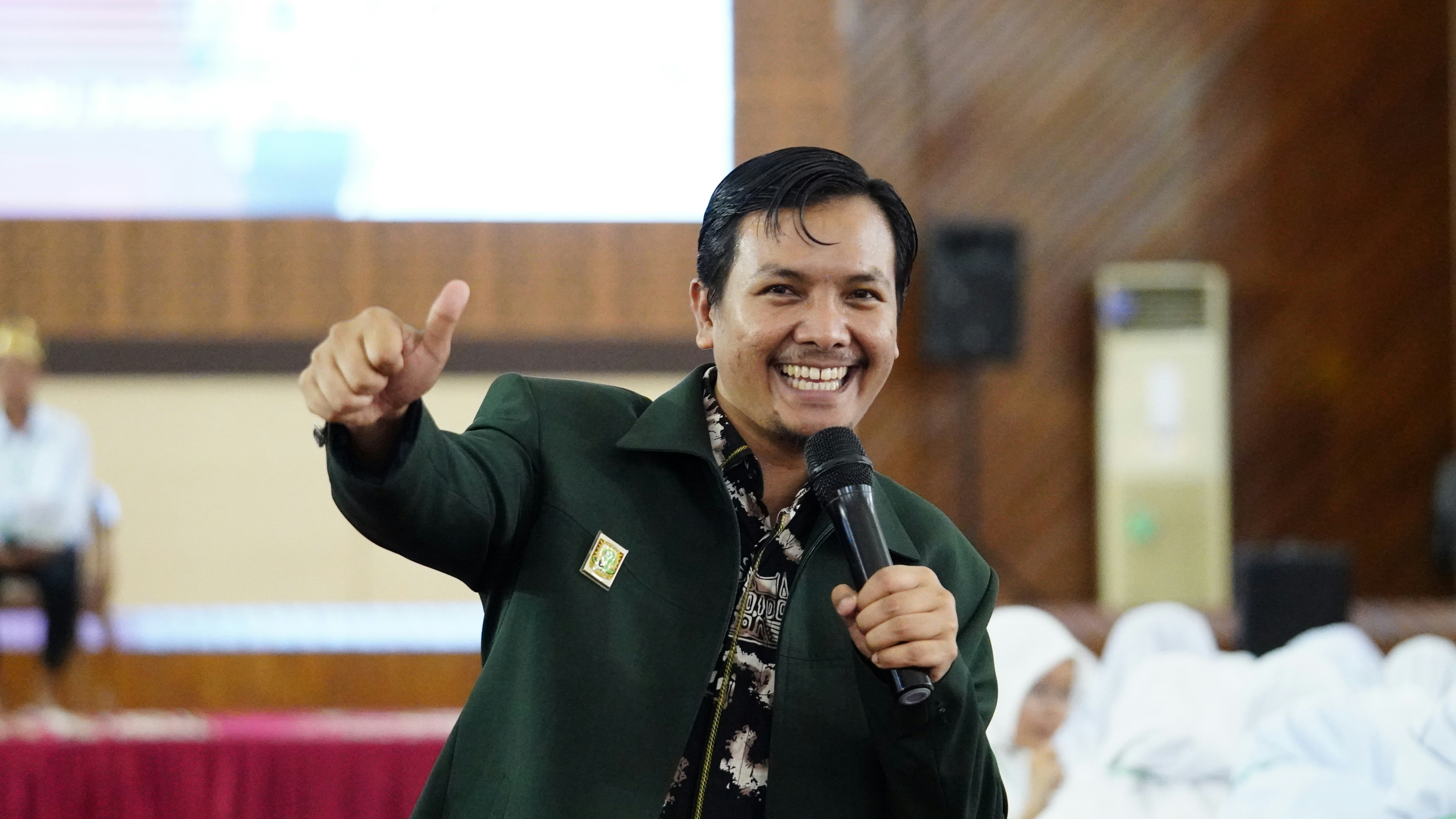 A man giving a thumbs up while holding a microphone photo – Free Tomb ...