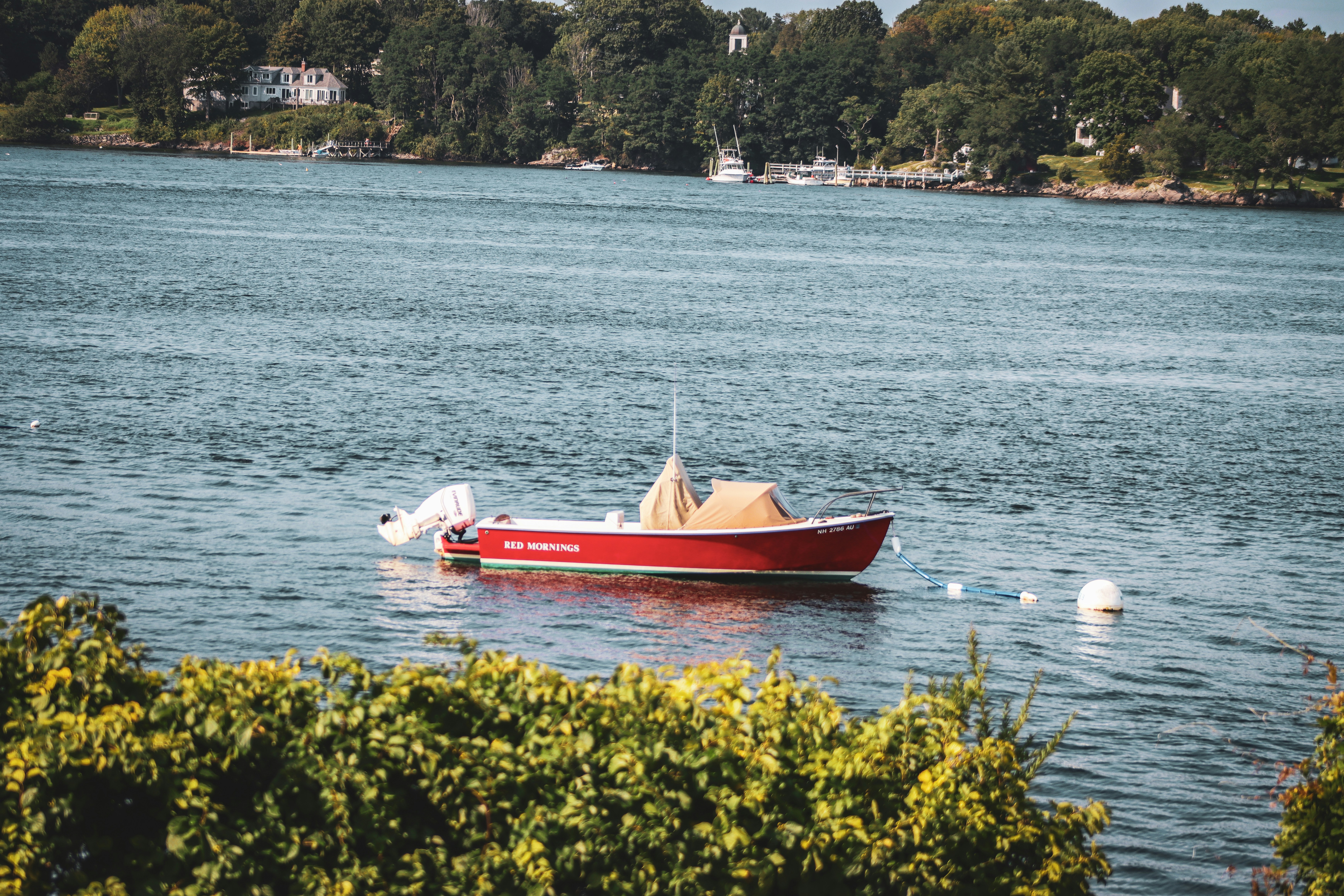 a red boat floating on top of a lake