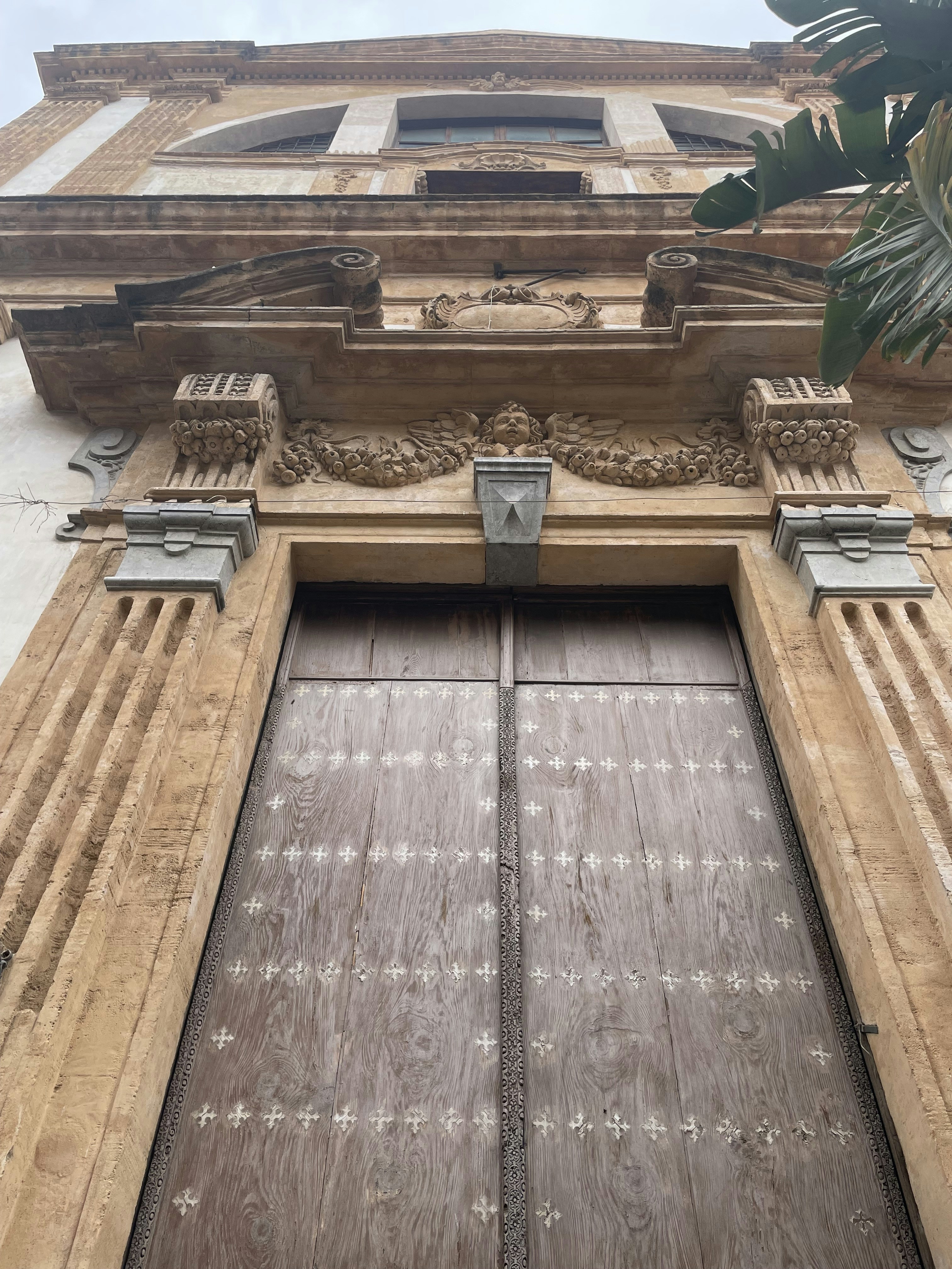 A tall building with two large wooden doors photo – Free Building Image ...