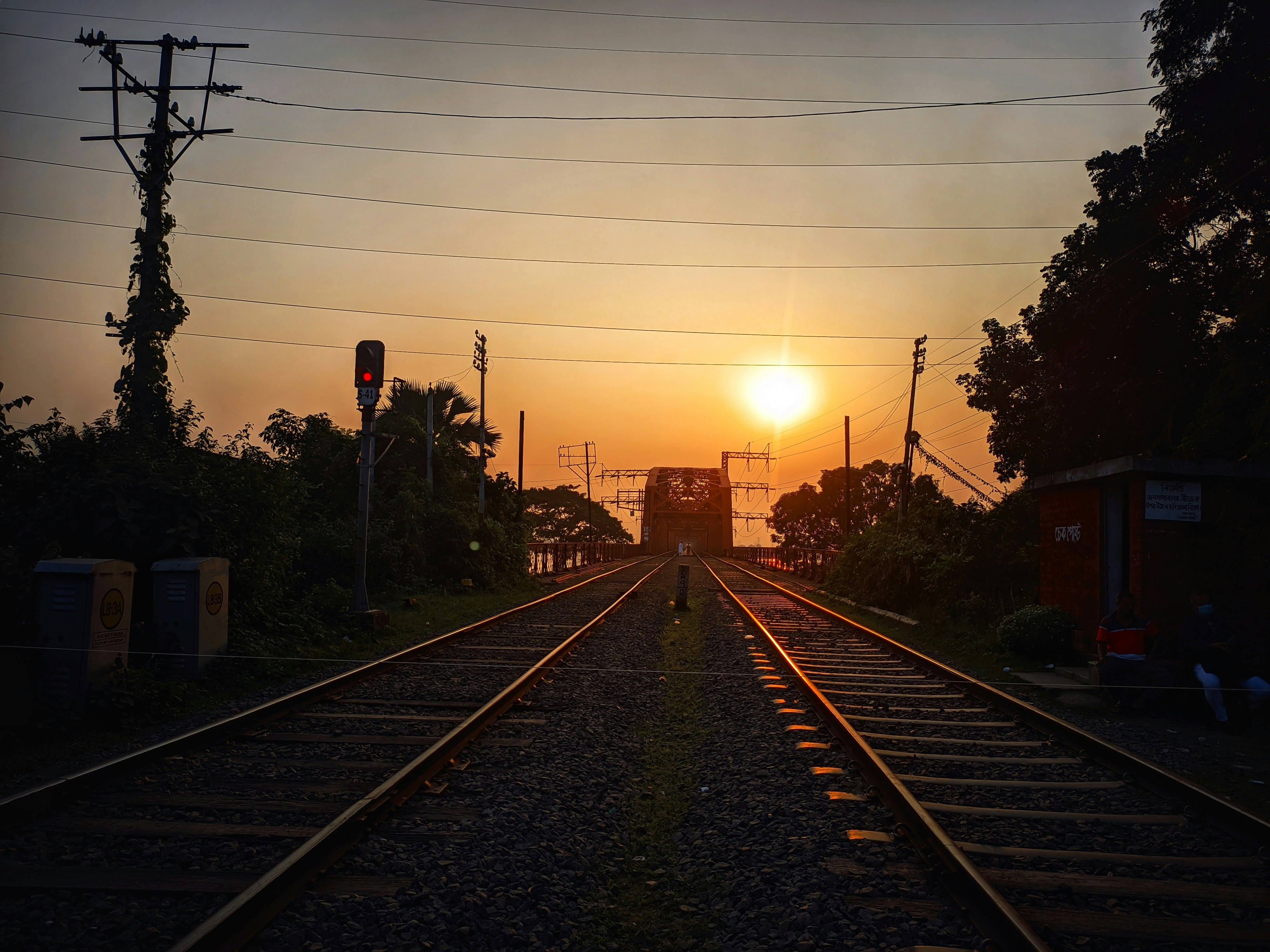 A train track with the sun setting in the background photo – Free ...