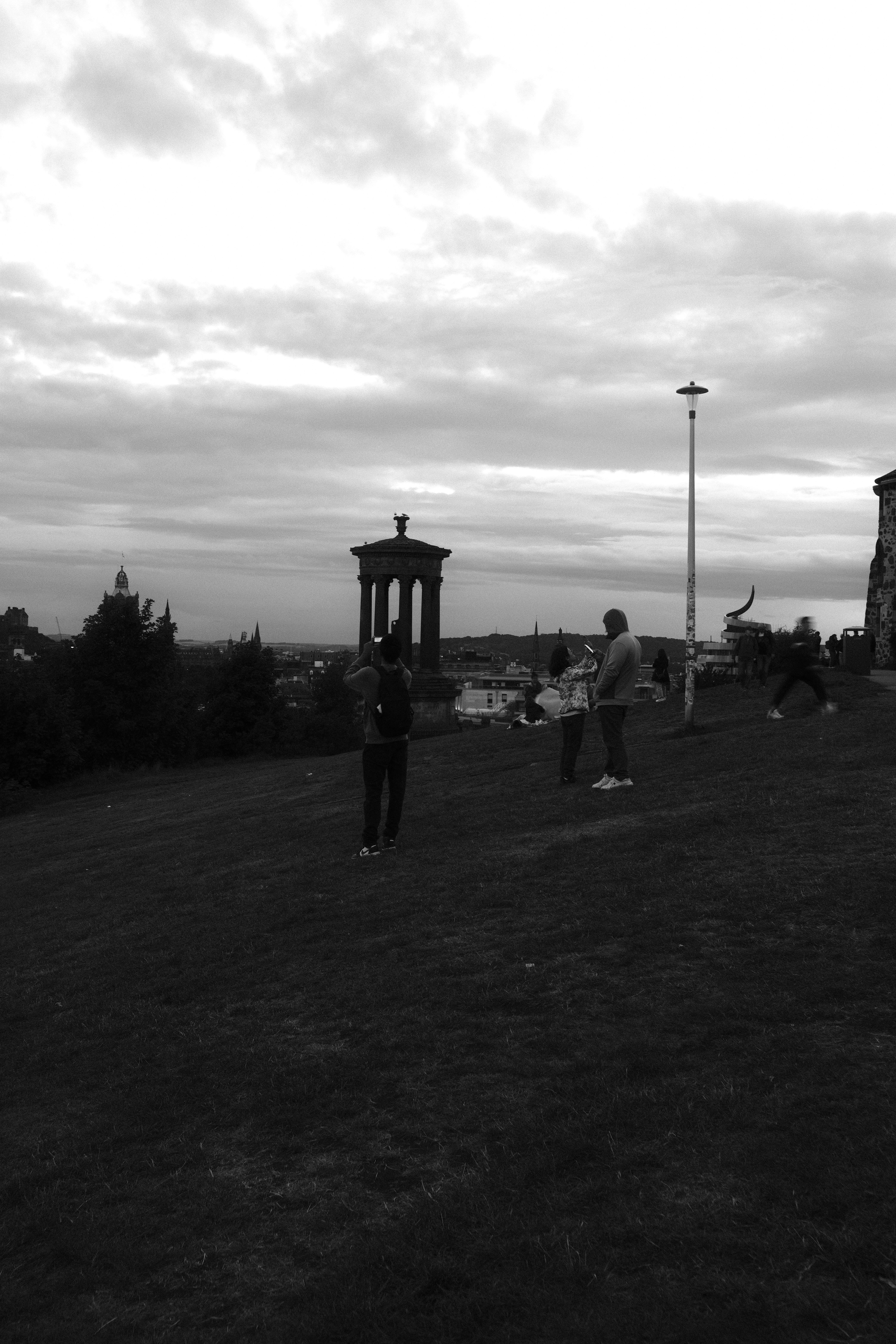 Silhouetted Explorers at a Hilltop Monument