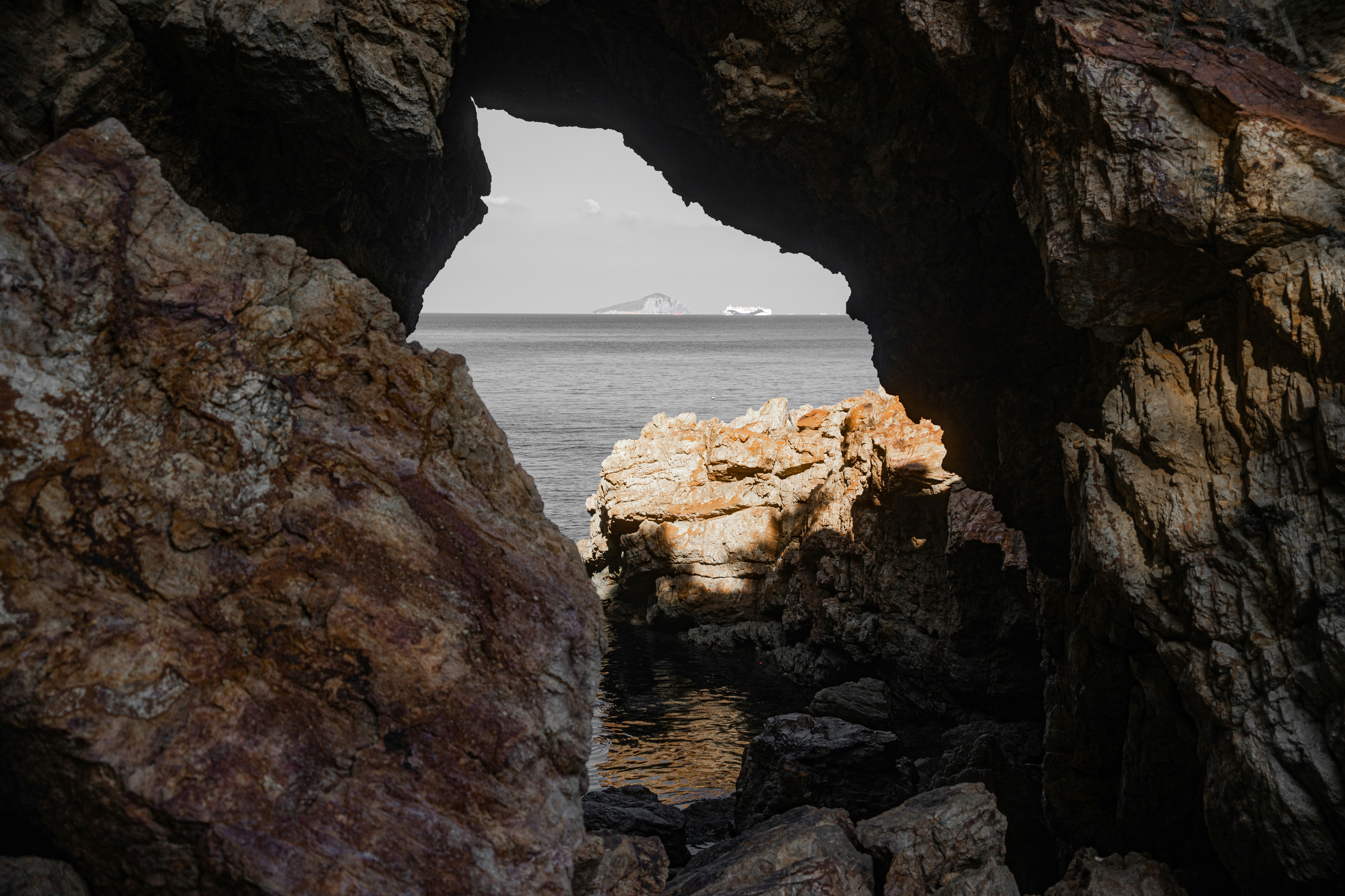 A rock formation with a hole in the middle of it photo – Free Sea Image ...