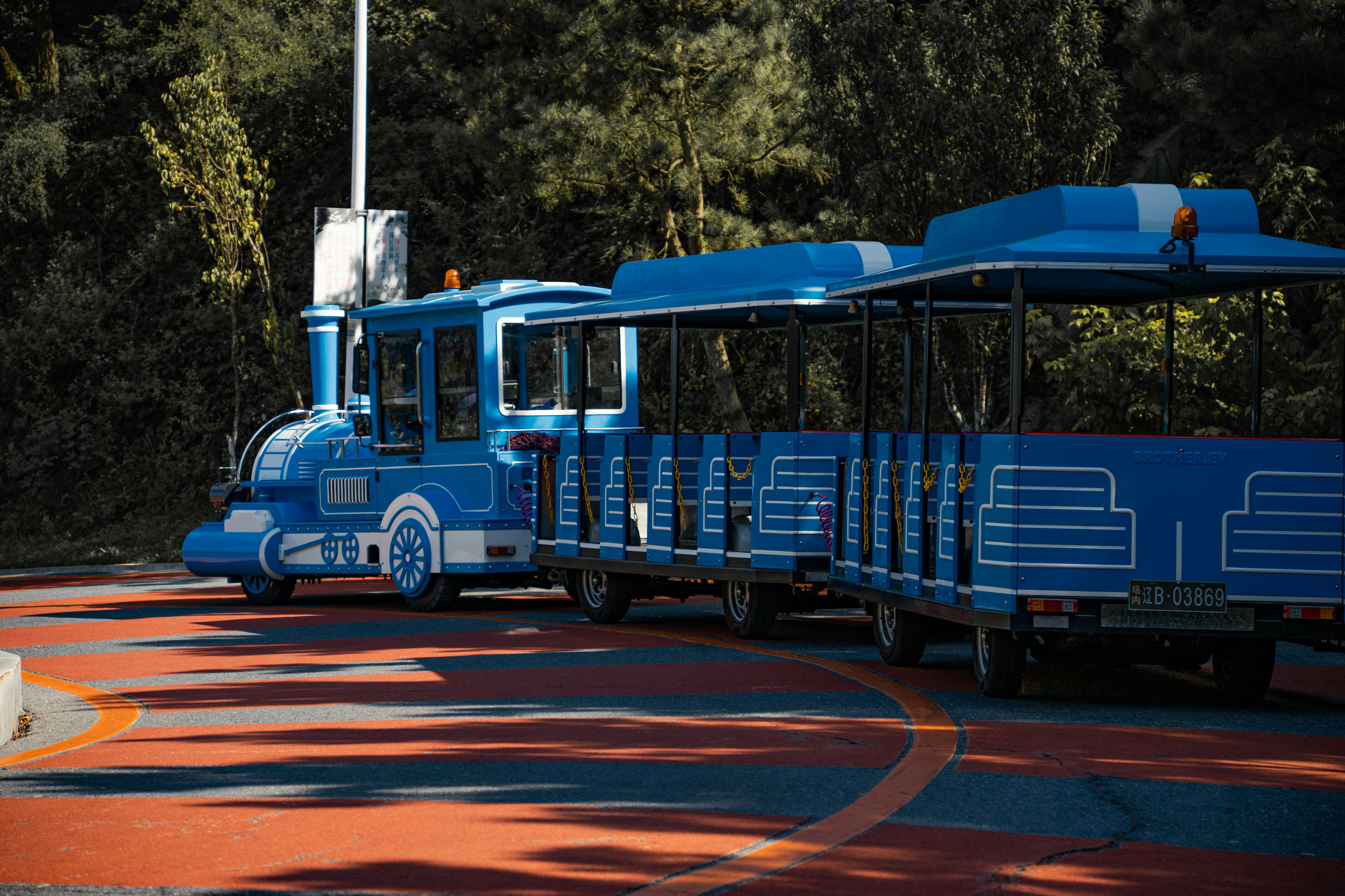Blue Locomotive Ride at a Sunlit Park Turn