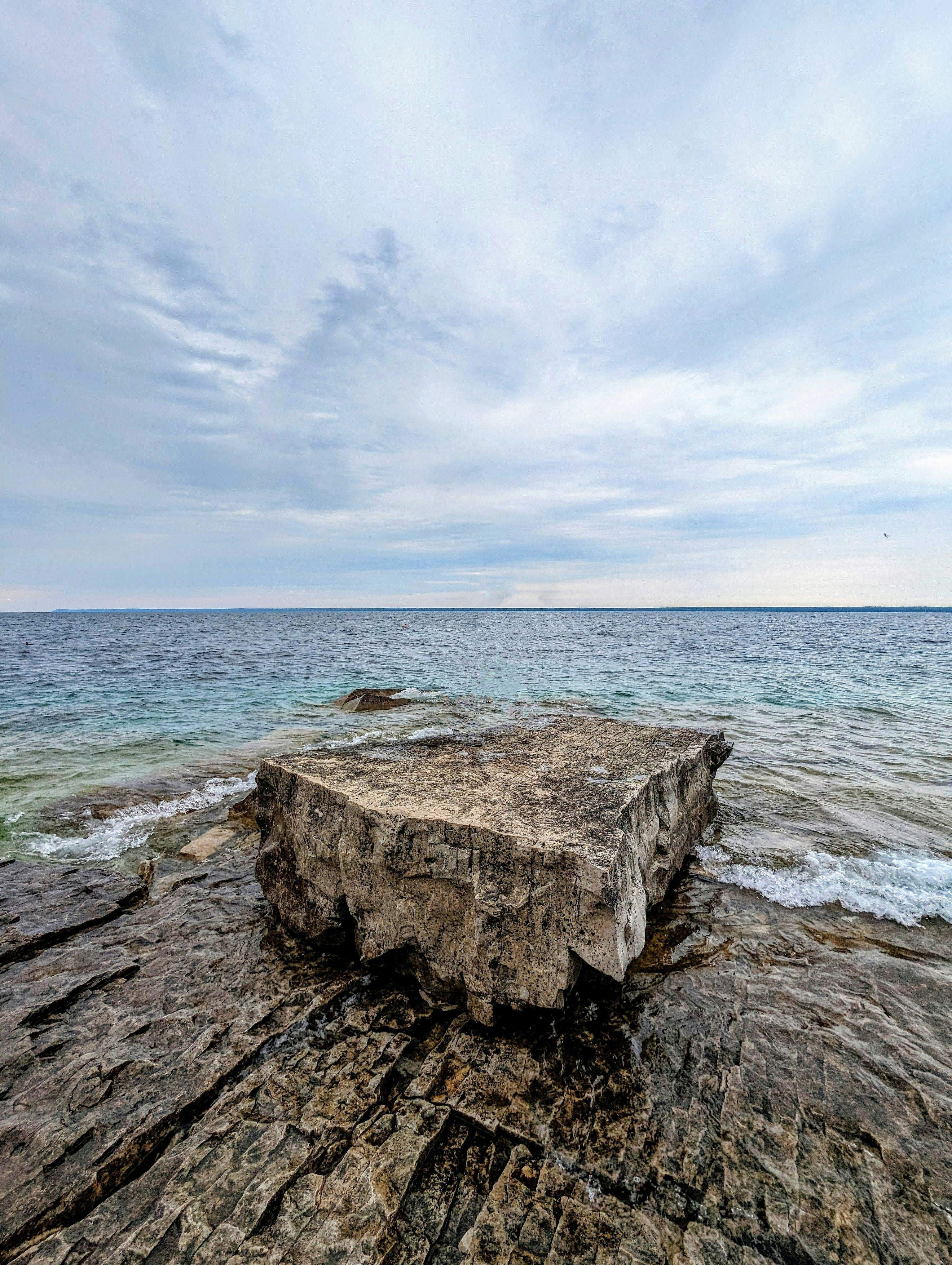Un gros rocher assis au sommet d’une plage au bord de l’océan photo ...