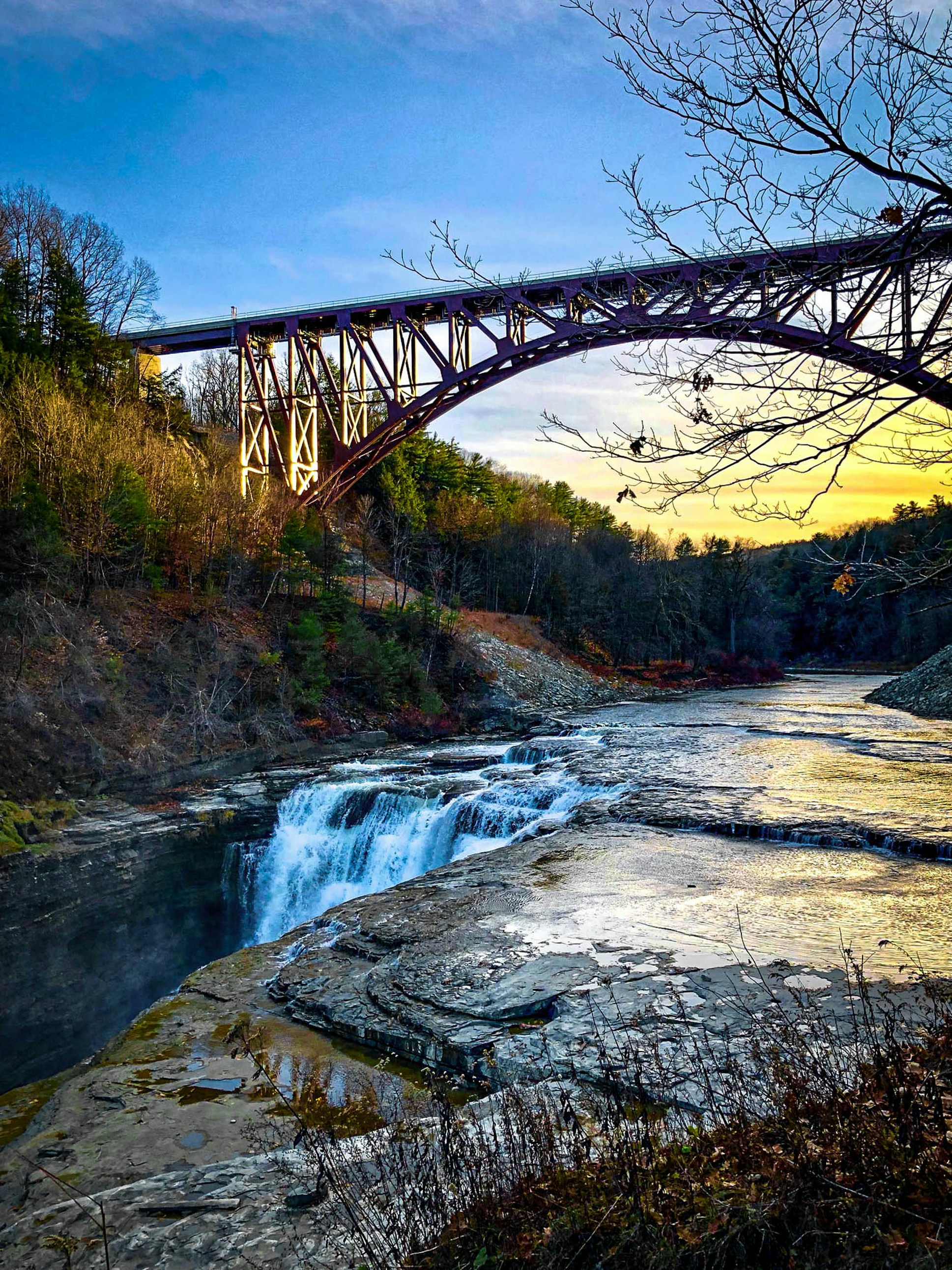 A bridge over a river with a waterfall below photo – Free Scenery Image ...