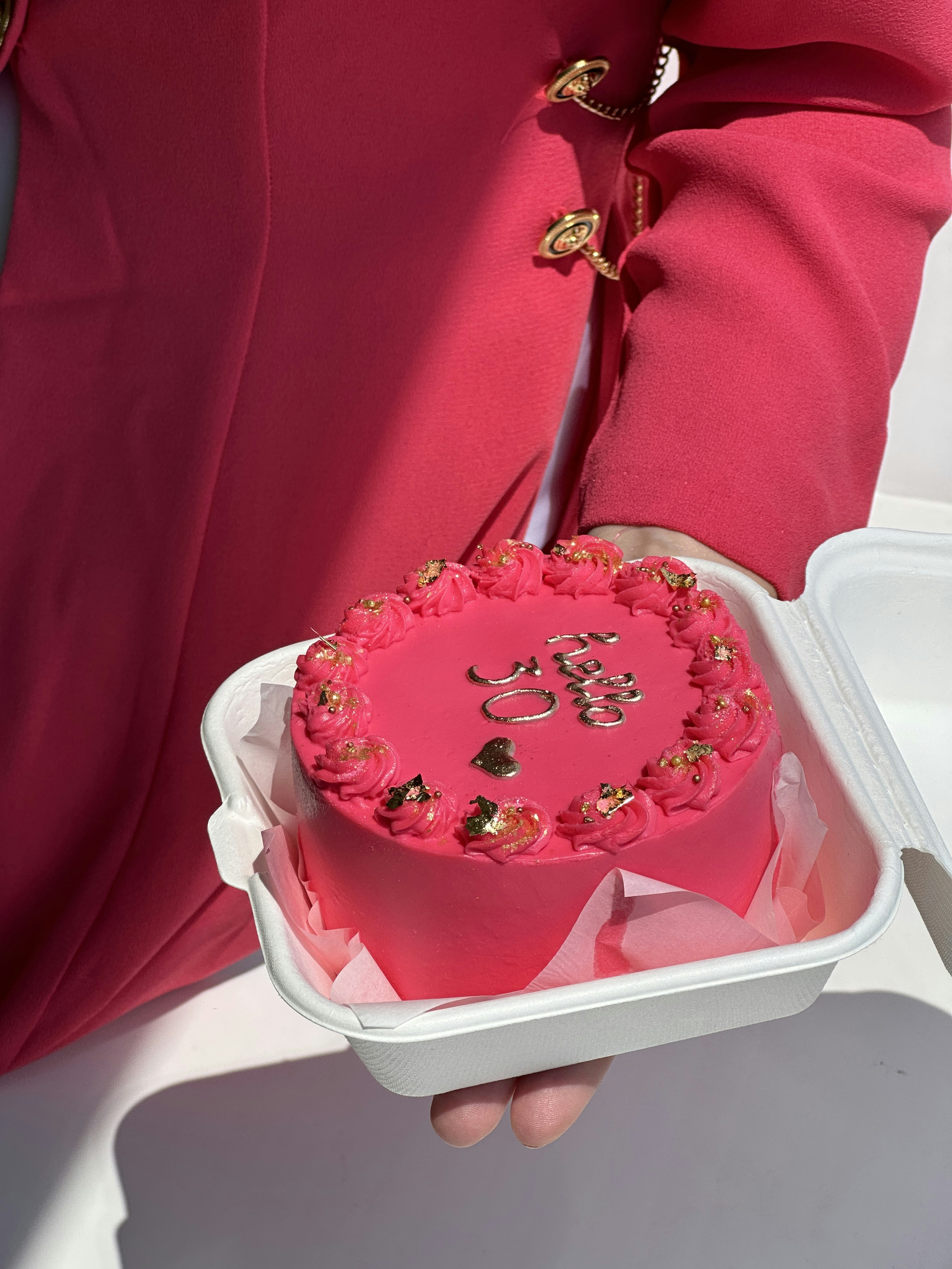 Crimson Coat, Pink Celebration: A Close-Up Moment in a Foam Box