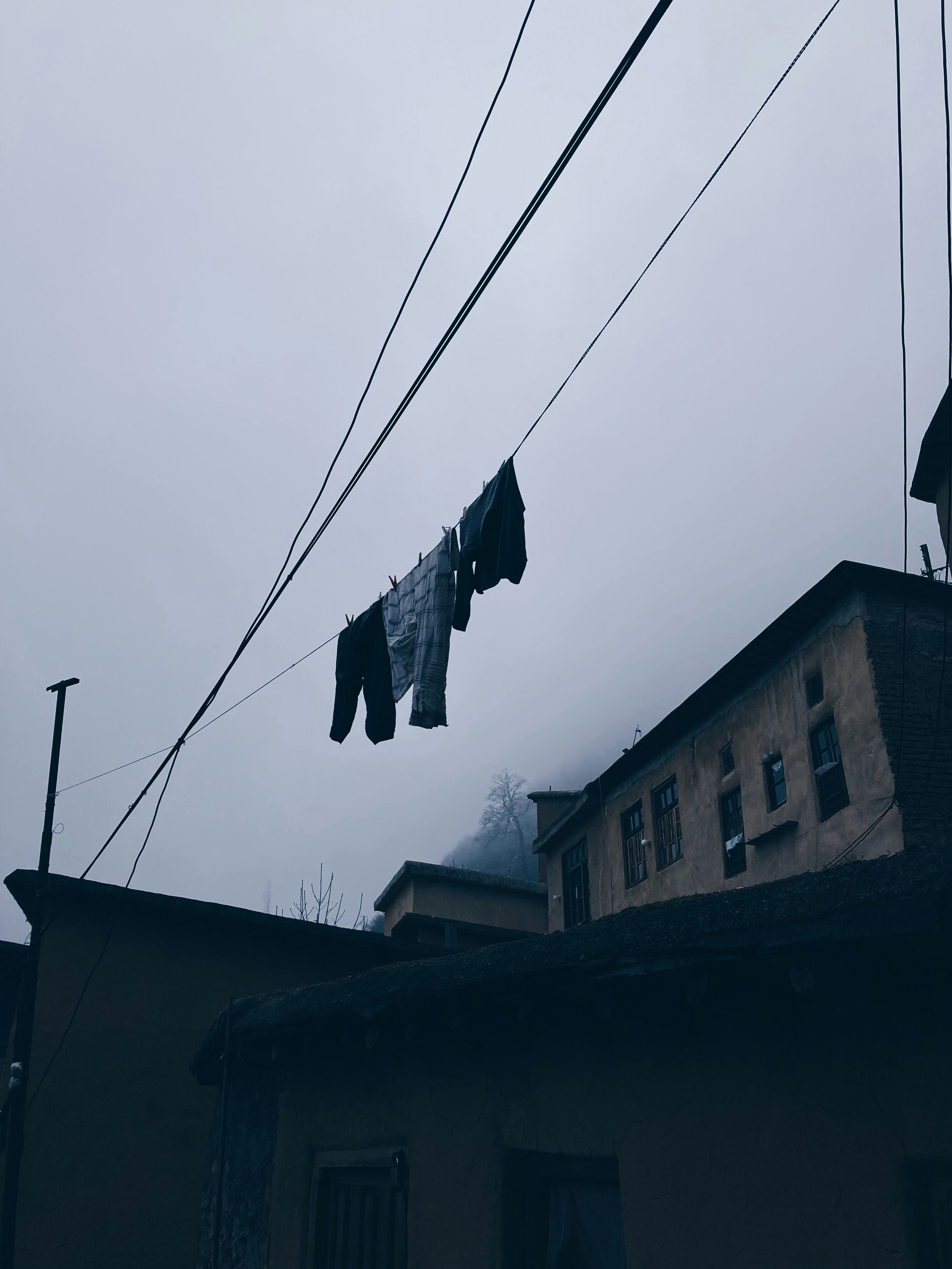 Laundry Lines in Fog: A Quiet Blue Hour Over Rooftops