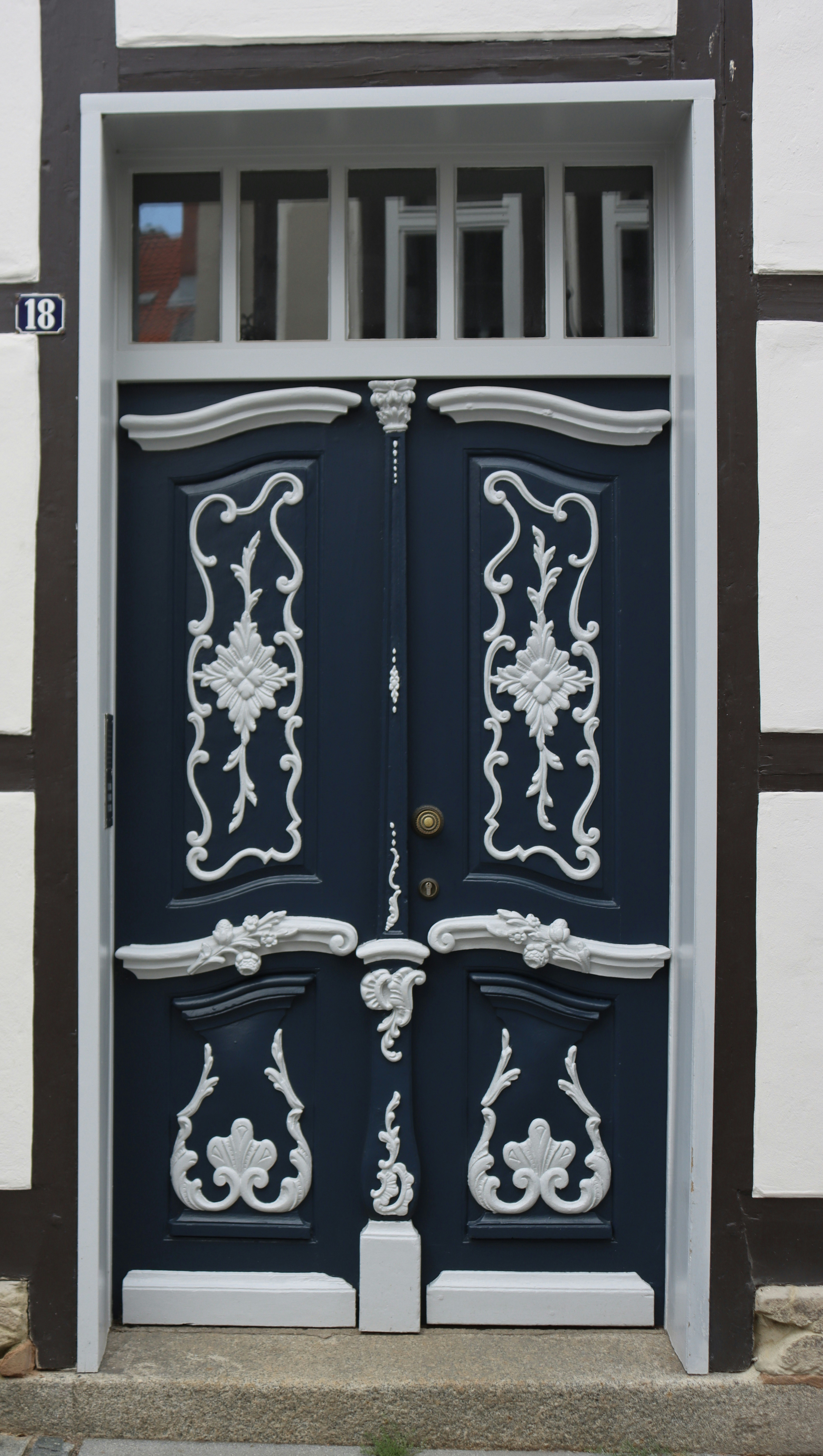 Ivory Scrollwork on a Navy Door: A Historic Facade's Quiet Focal Point