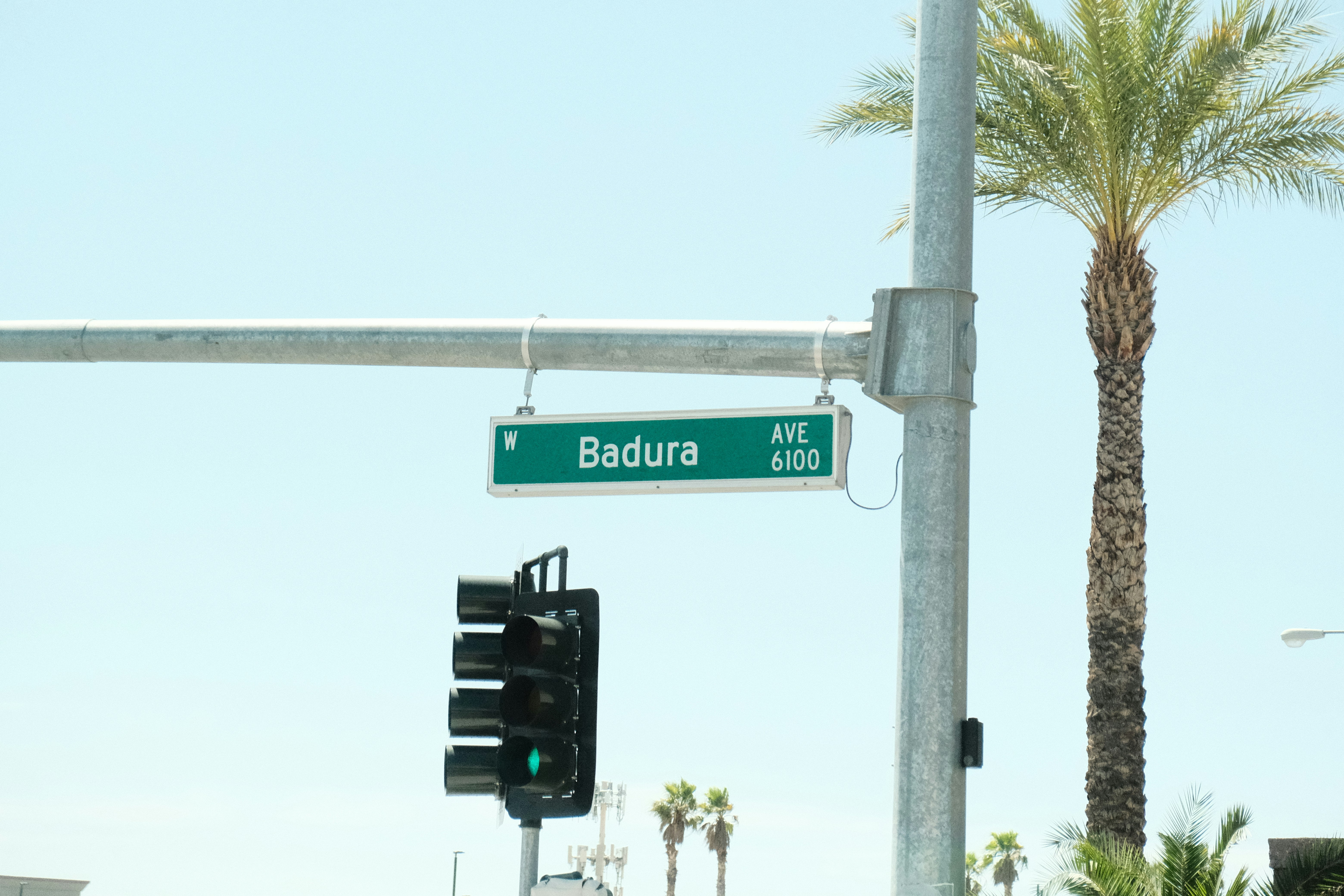 Badura Ave: Palm-Frame and a Green Street Sign in a Sunlit Desert Intersection