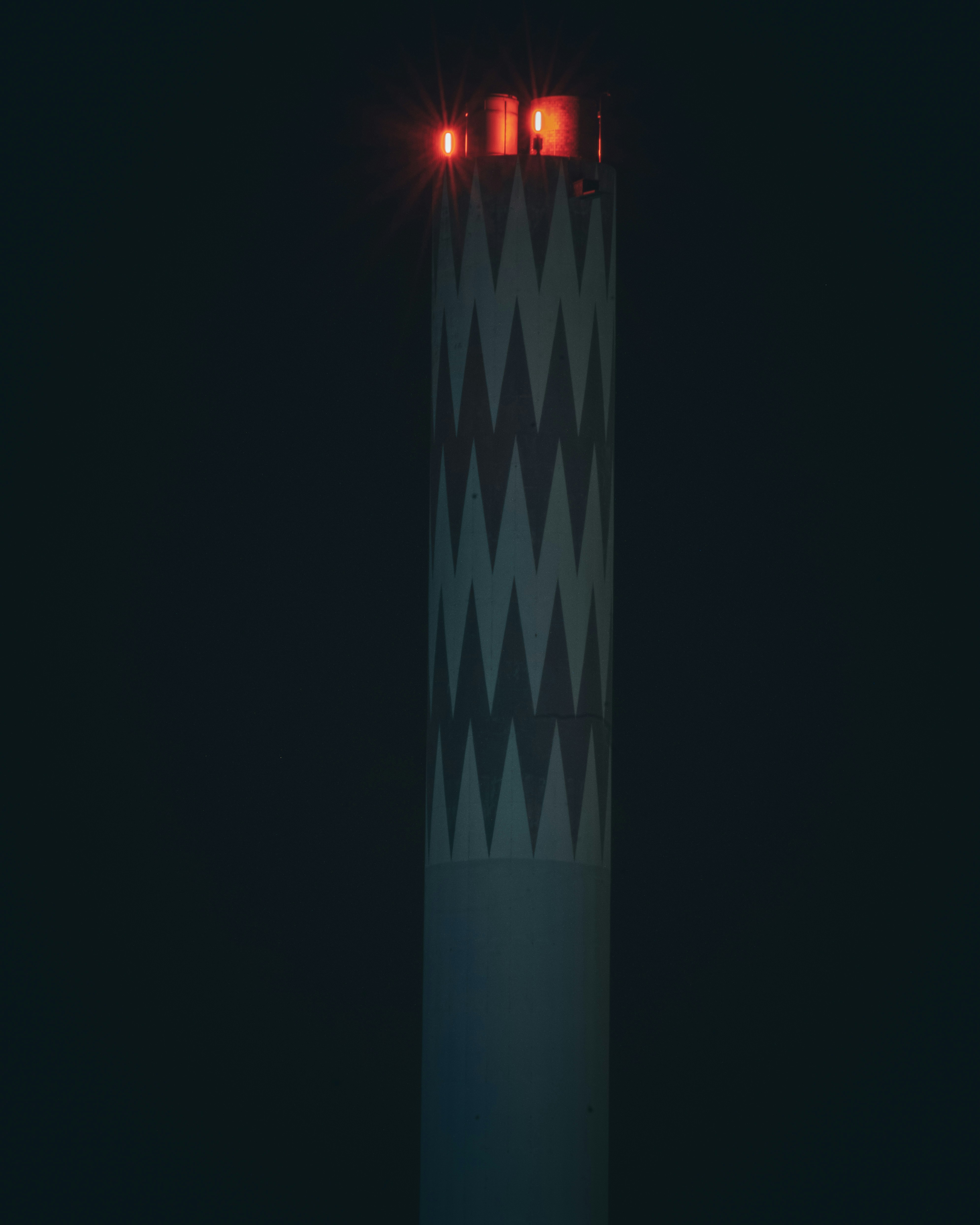 Red Beacon Over a Diamond-Wrapped Tower in the Night Sky