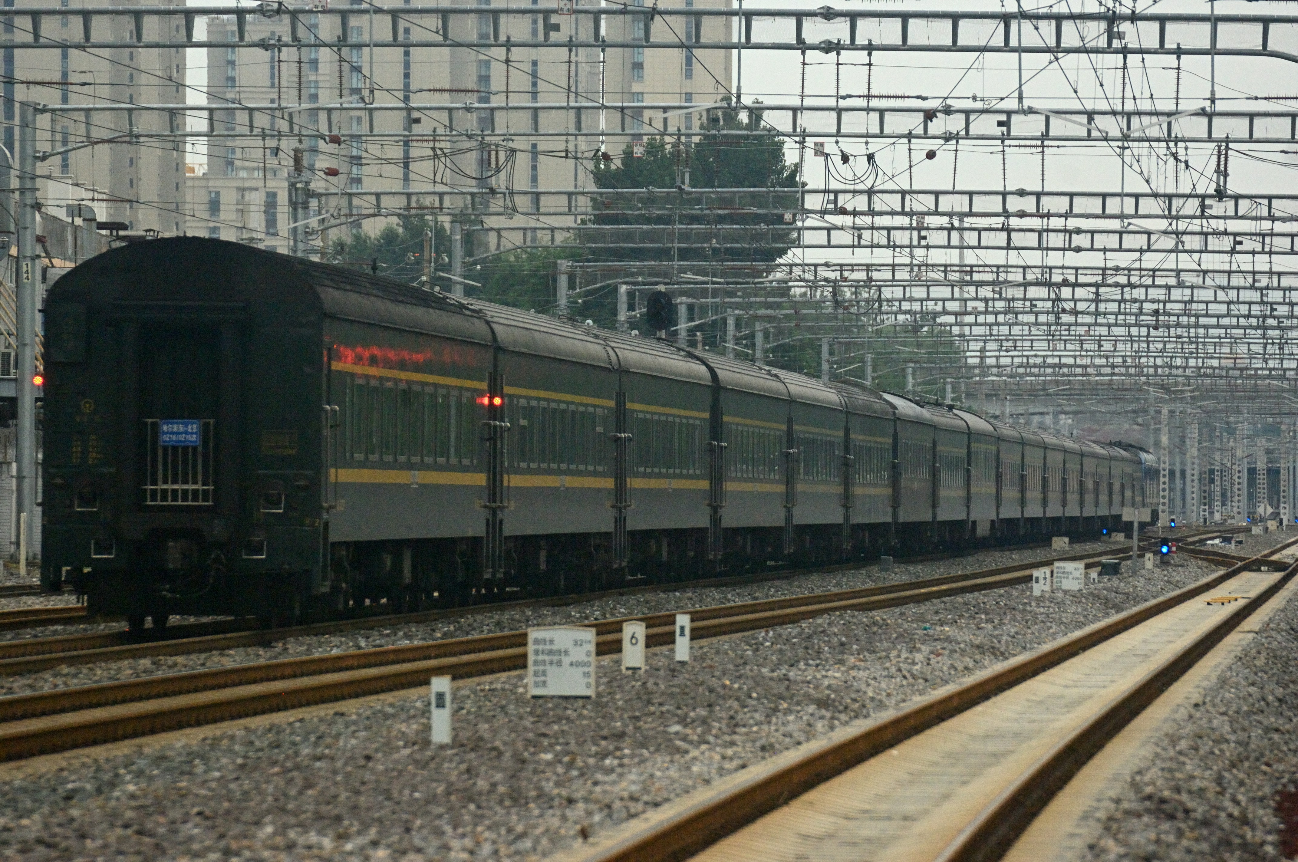 A train traveling down train tracks next to a tall building photo ...