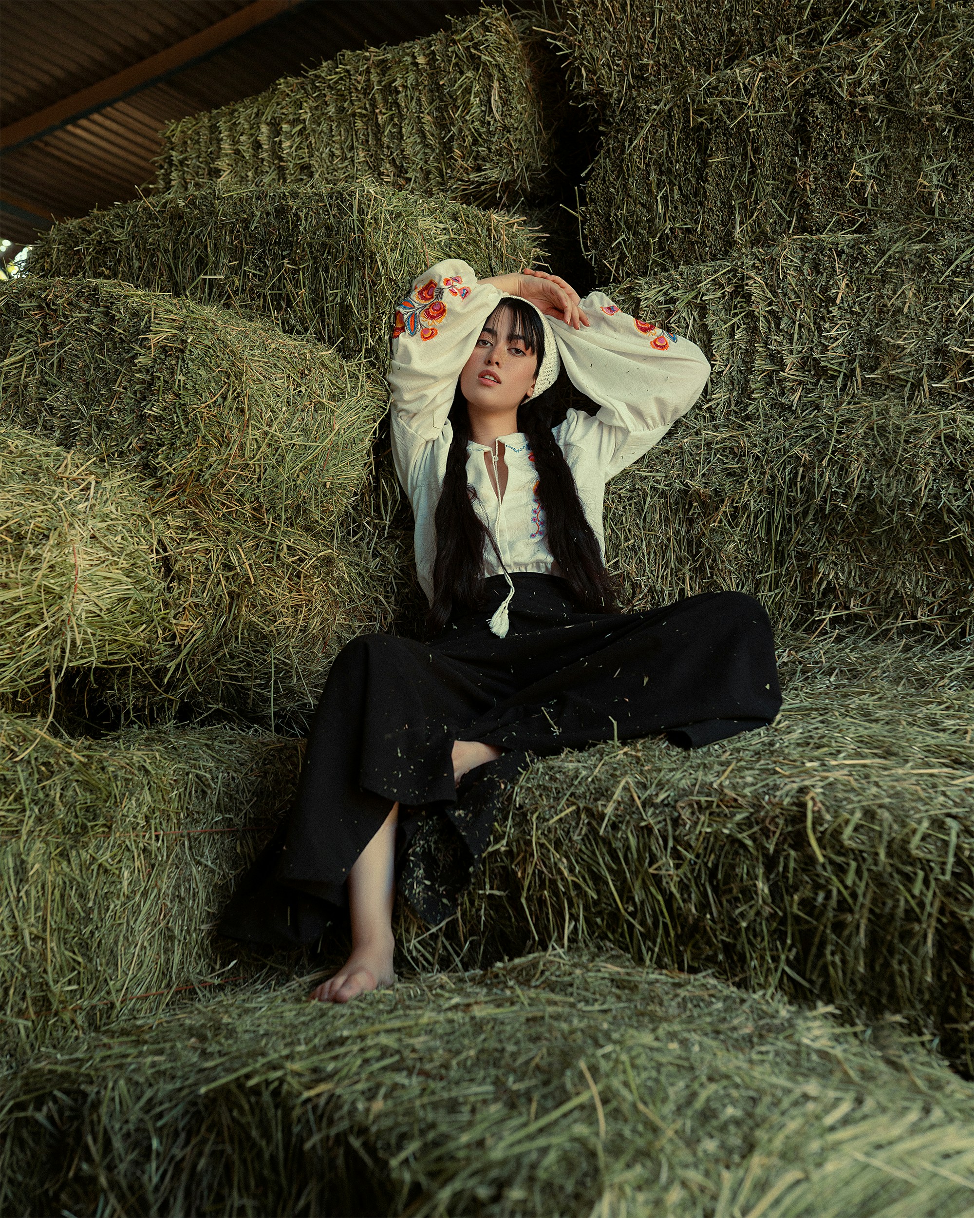 Harvest Quiet: A Studio Portrait Nestled Among Stacked Bales