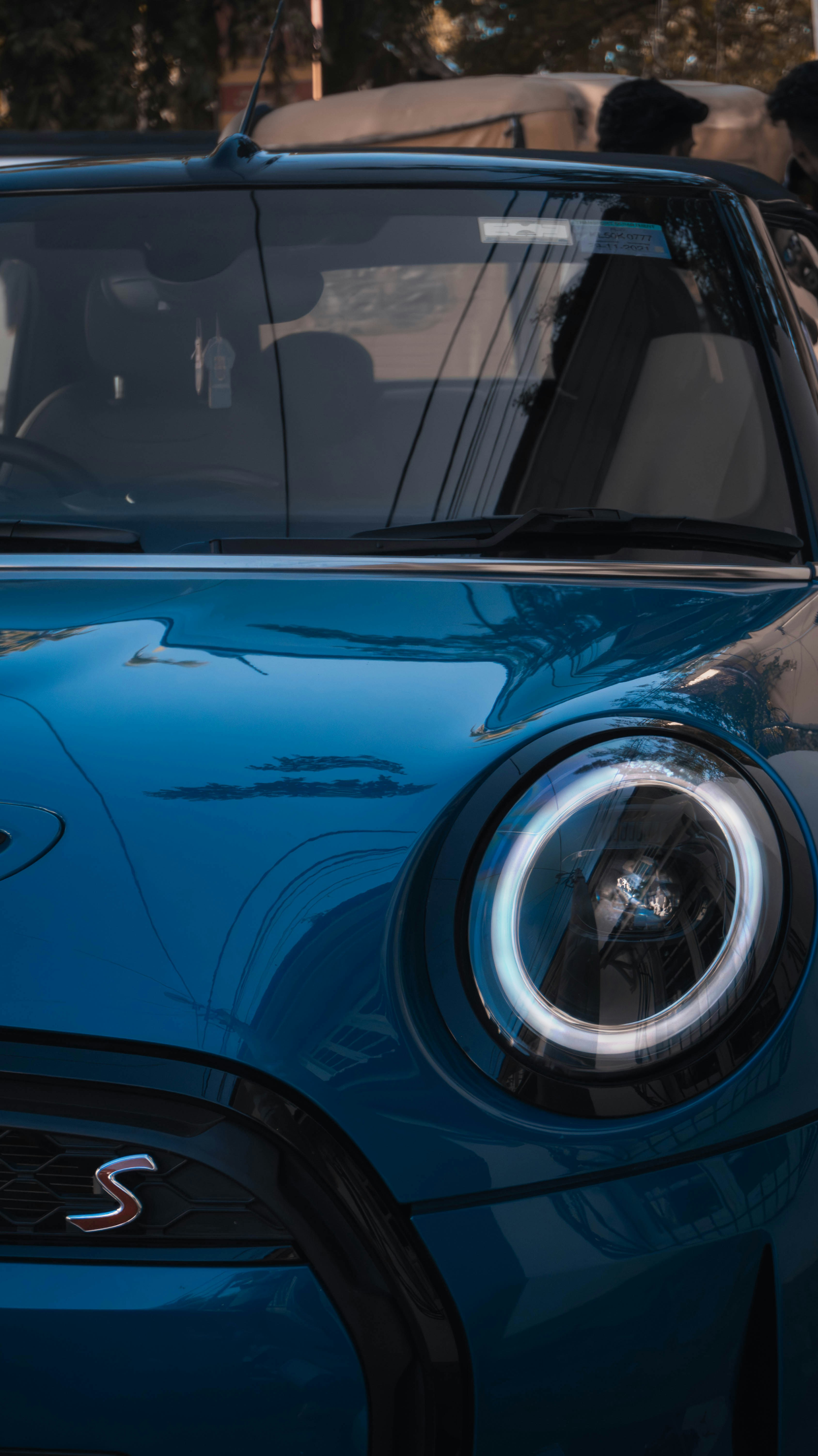 A close up of the front of a blue mini cooper cooper cooper cooper ...