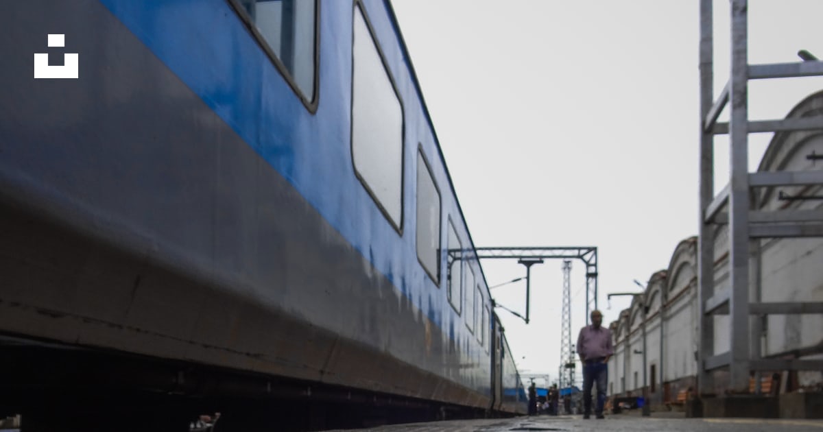 Un Homme Debout à Côté Dun Train Sur Une Voie Ferrée Photo Image