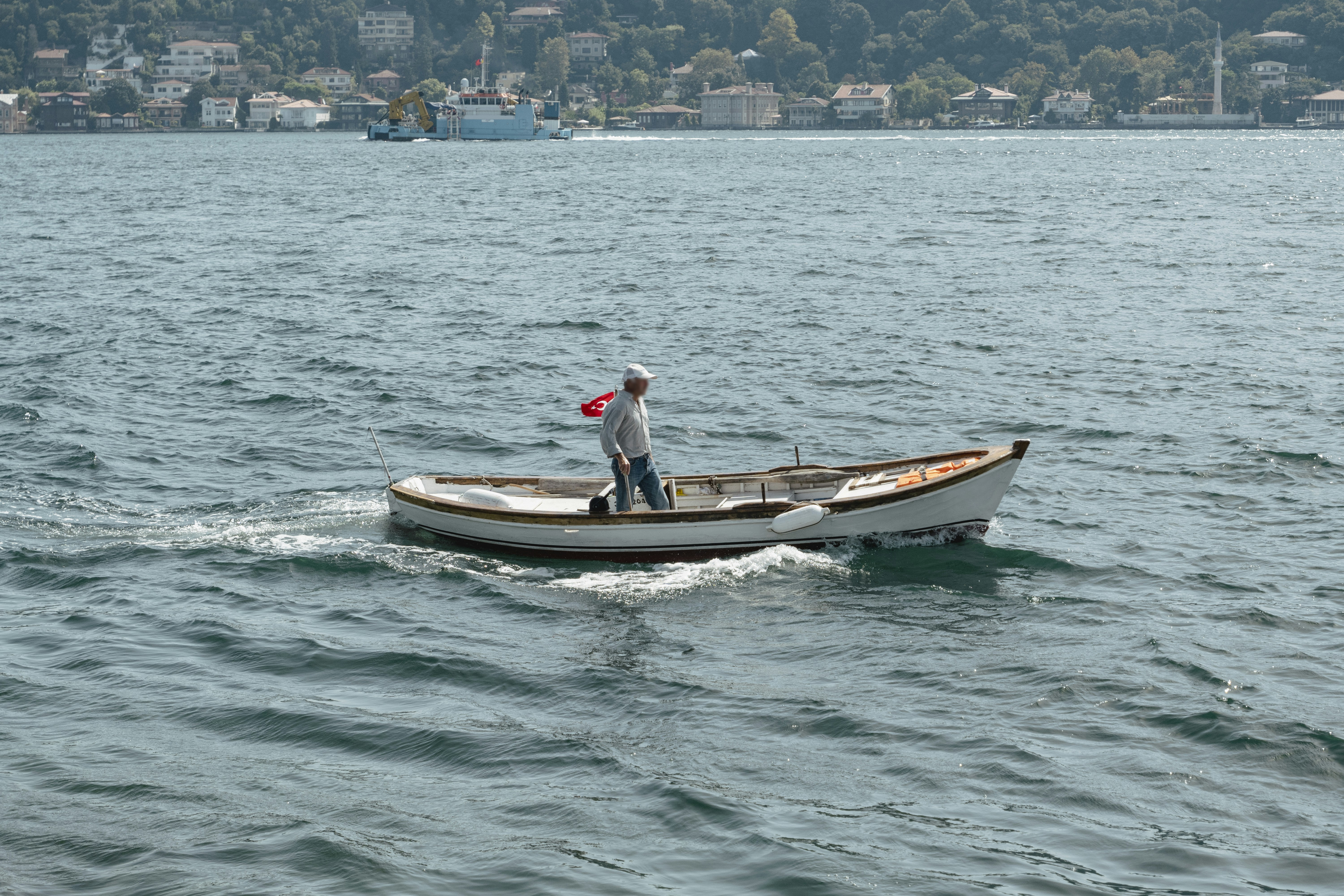 Red-scarfed Skipper: A Wooden Skiff Gliding Through Quiet Seas