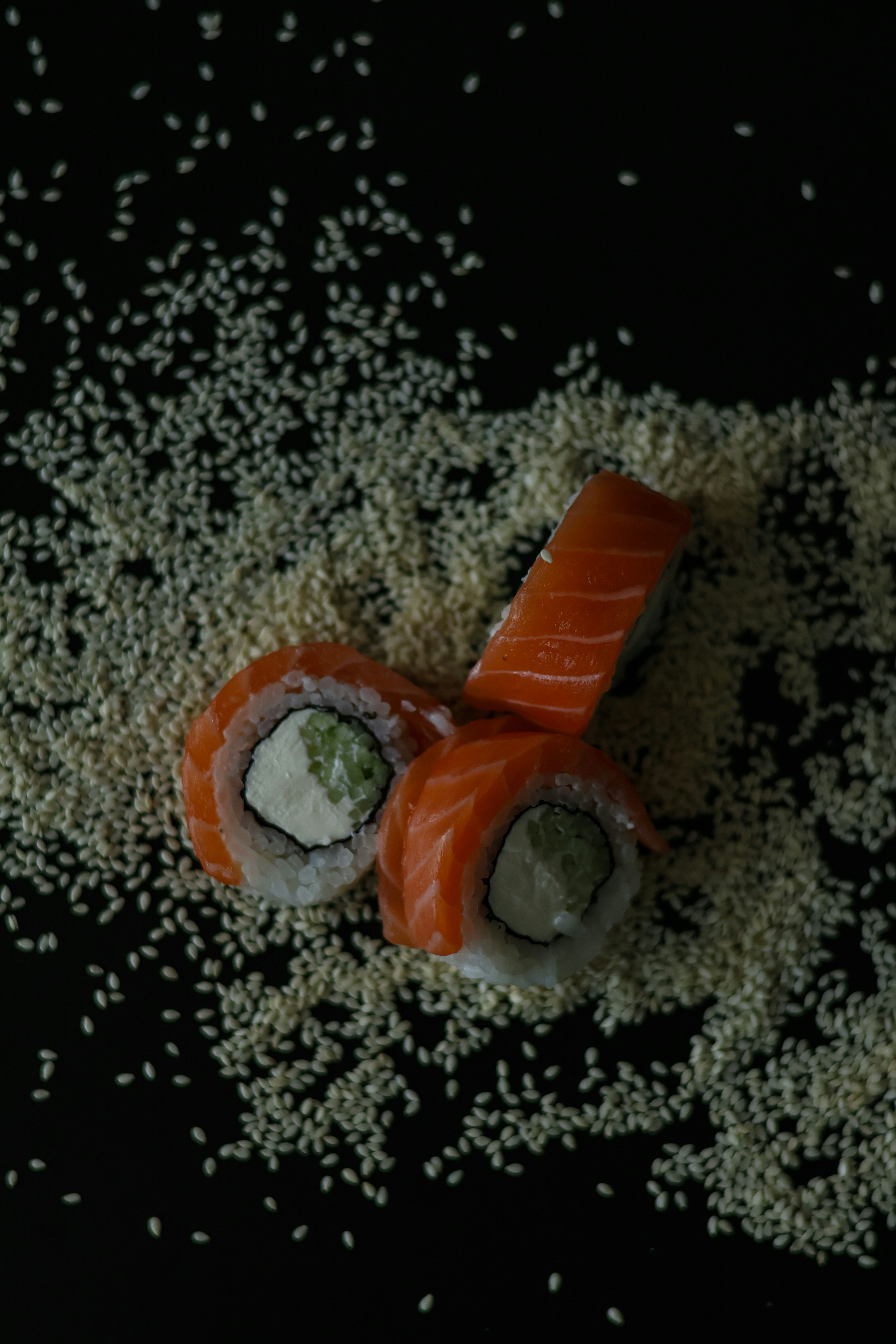 Salmon Nigiri Trio on a Sesame-Sprinkled Black Canvas