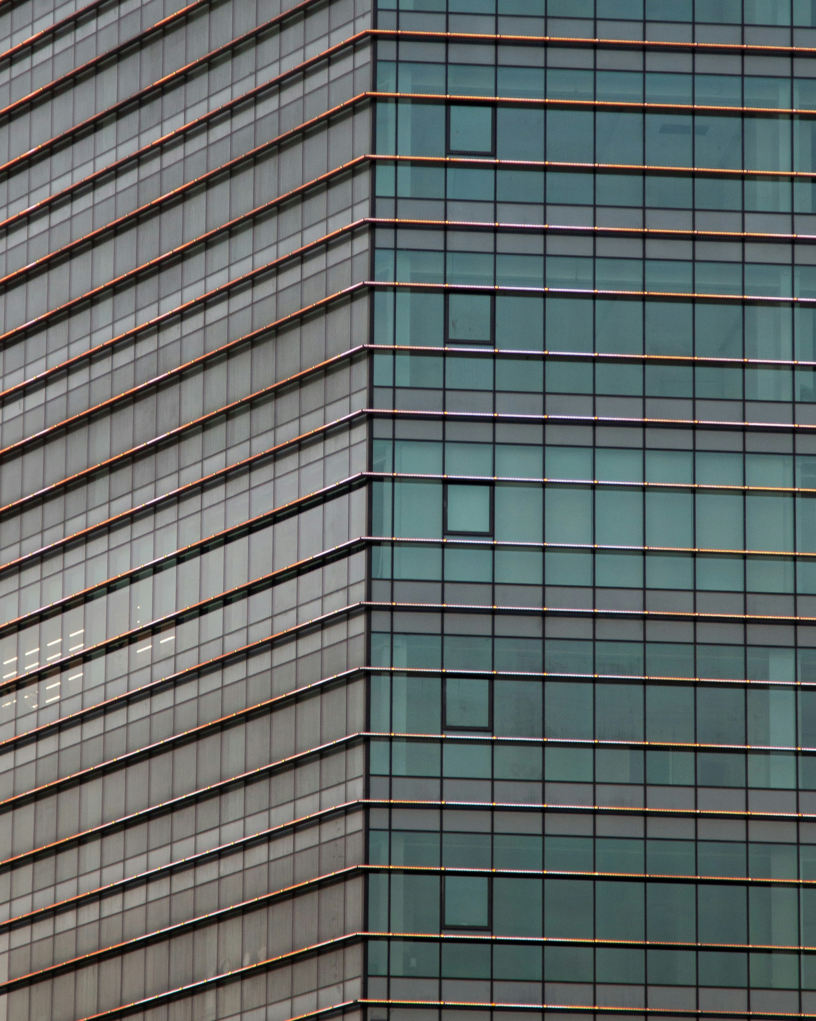 A plane flying in front of a very tall building photo – Free Building ...