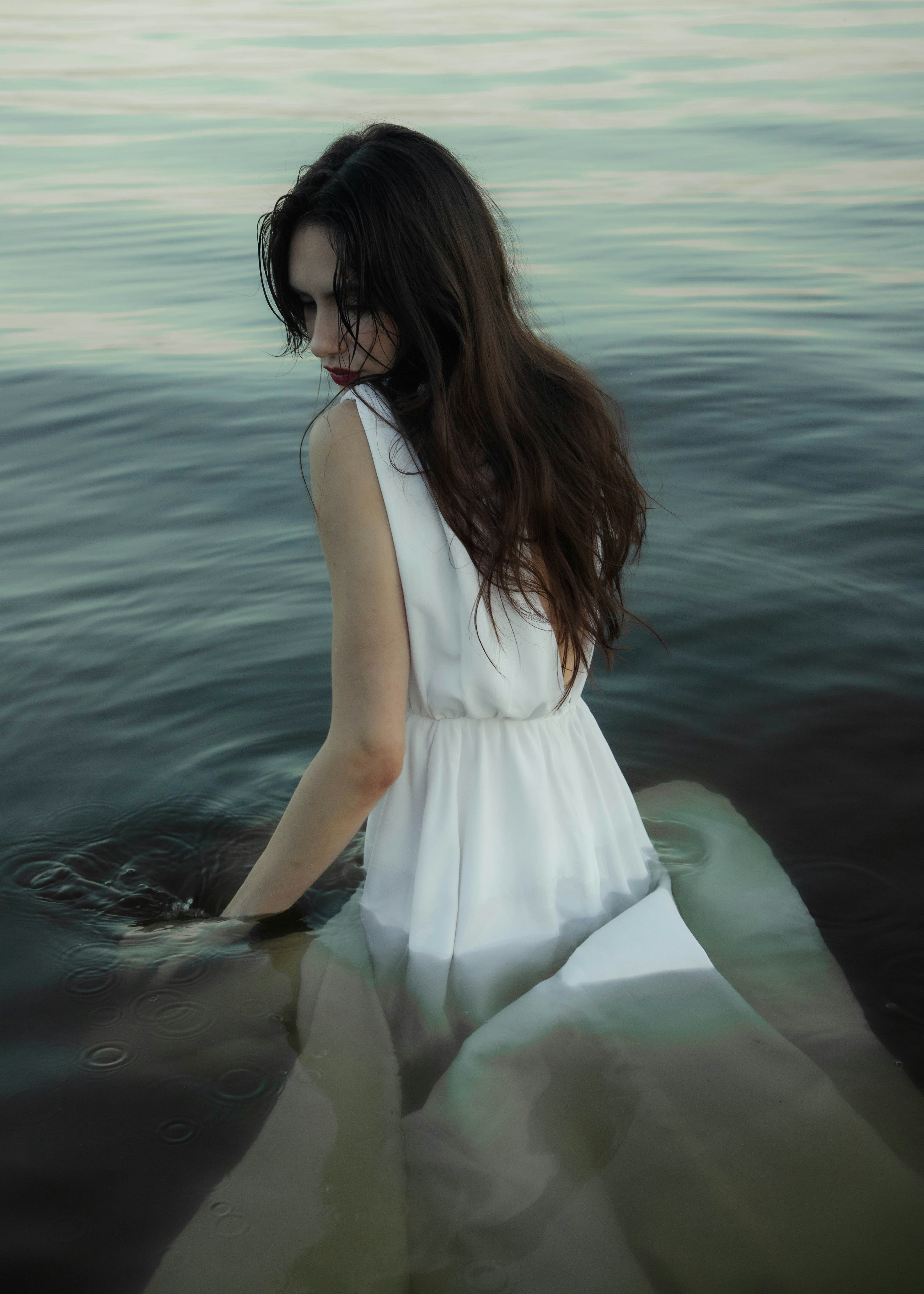A woman in a white dress standing in the water photo – Free Photography ...