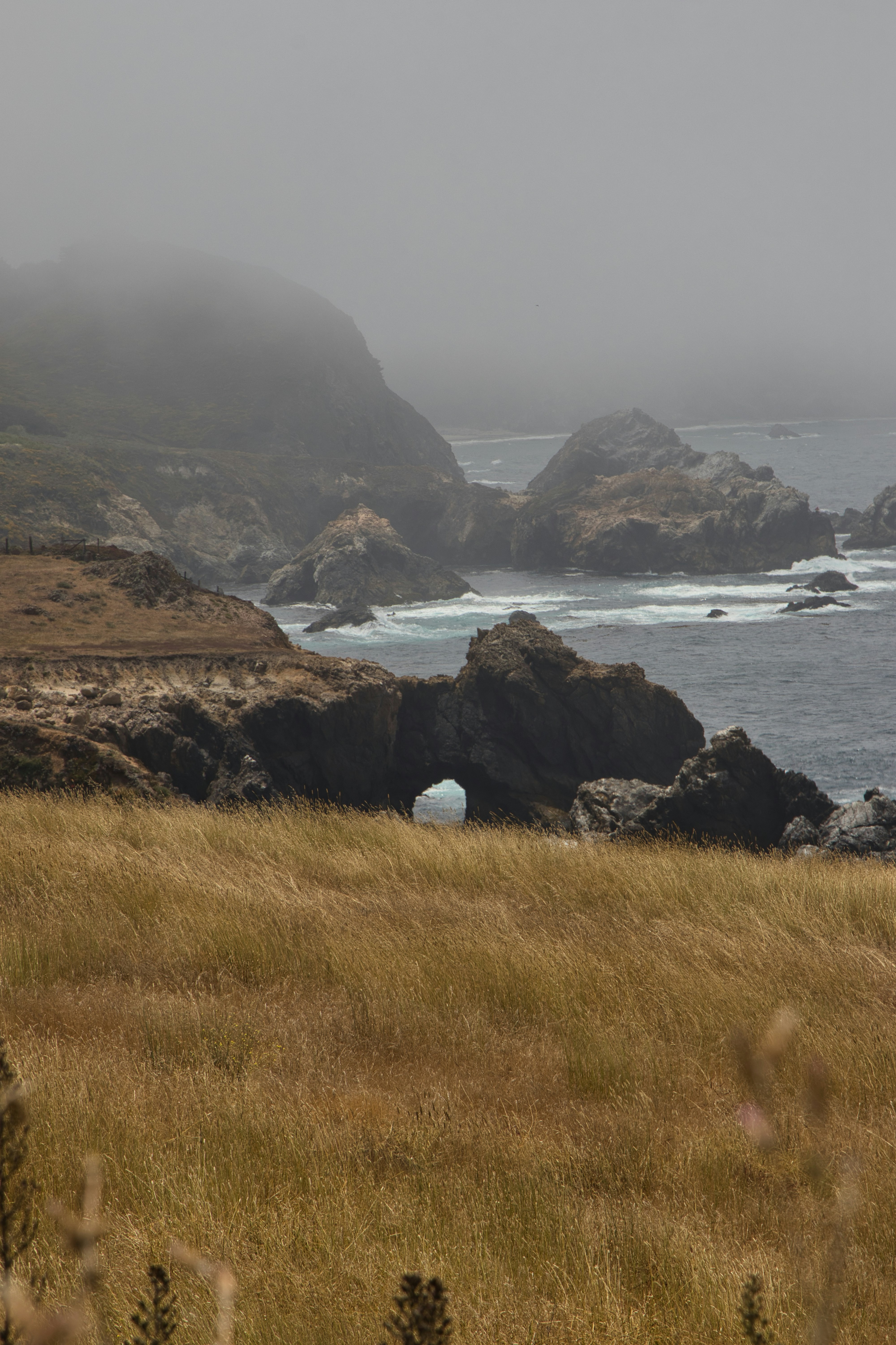 Mist-Hung Arch: Rugged Coastline Beneath Fog