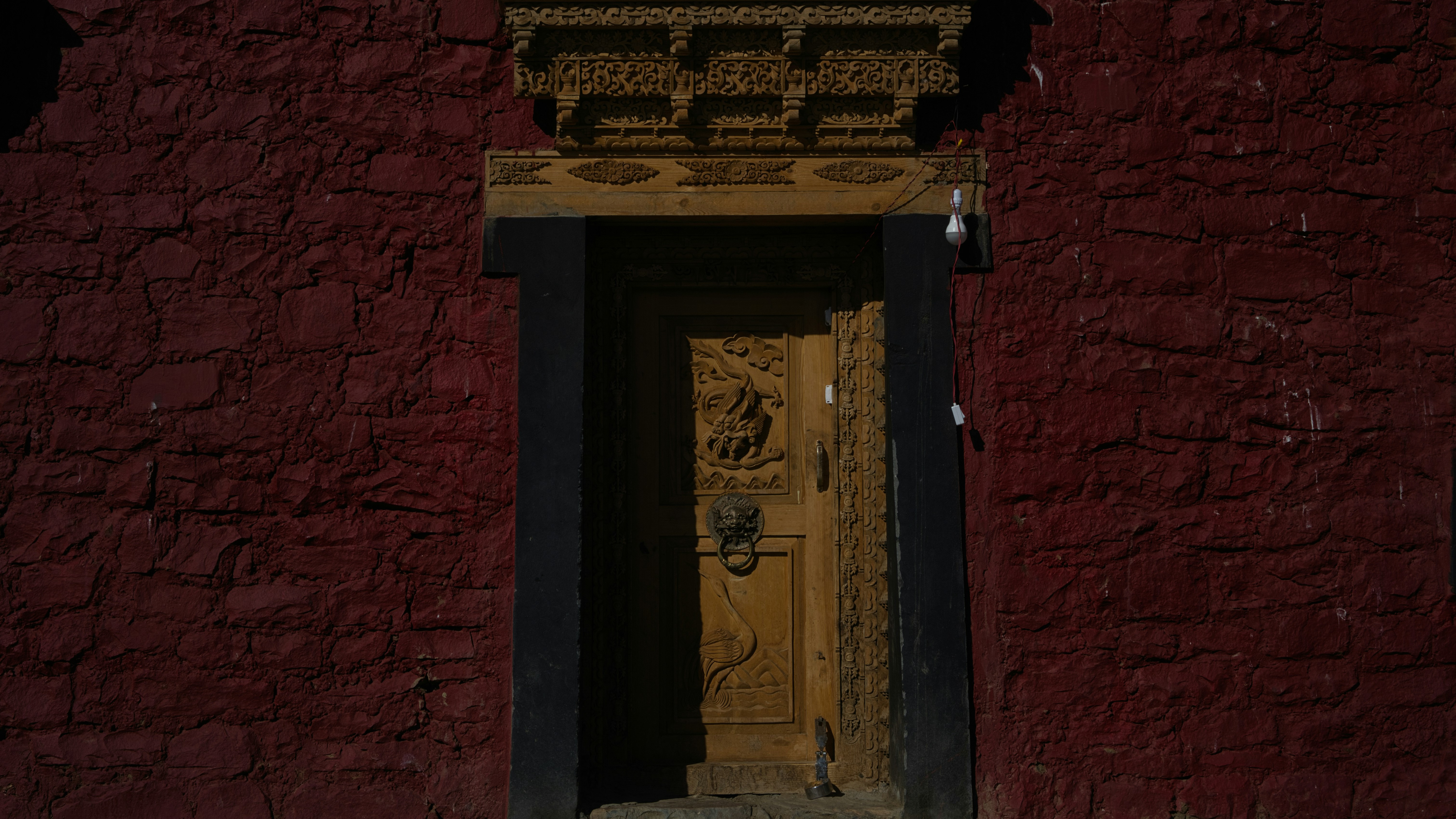 The Crimson Portal: An Ornate Door Framed by a Weathered Wall