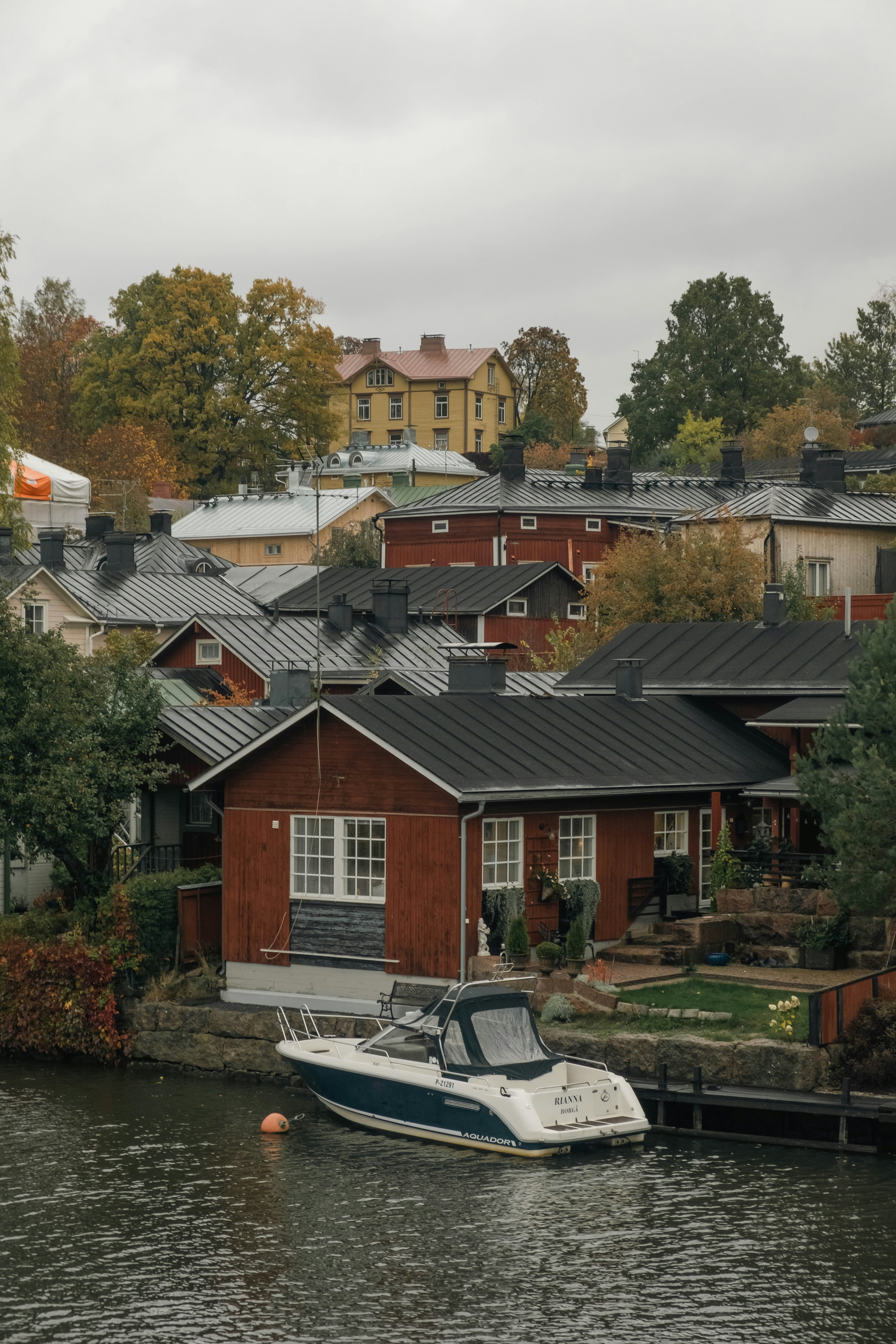 Harborfront Homes: Boats, Red Wood Cabins, and Autumn Ripples