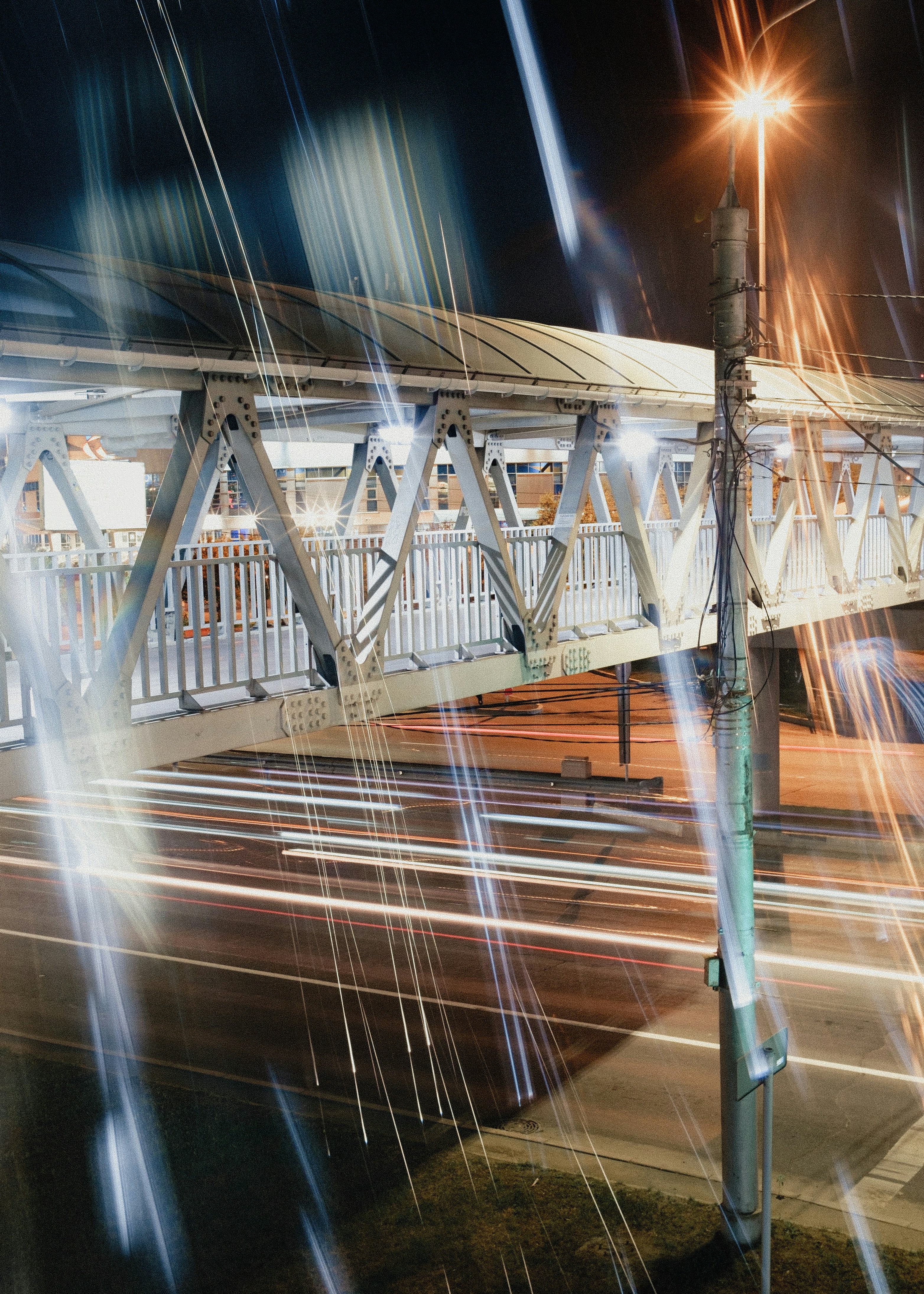 Neon Rain on the Steel Span: Light Trails across a Night Bridge