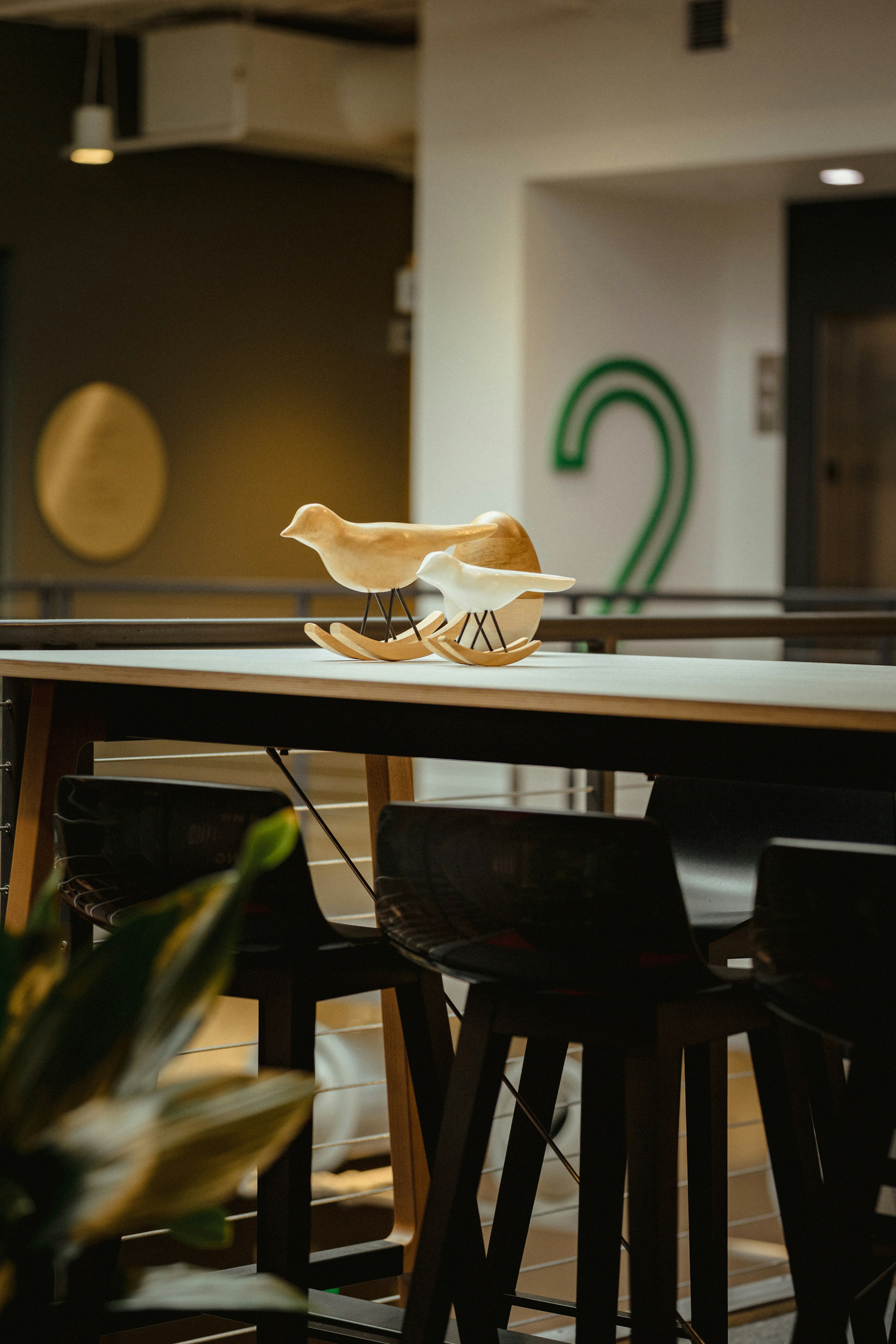 Minimalist wooden bird sculpture on a sunlit cafe counter