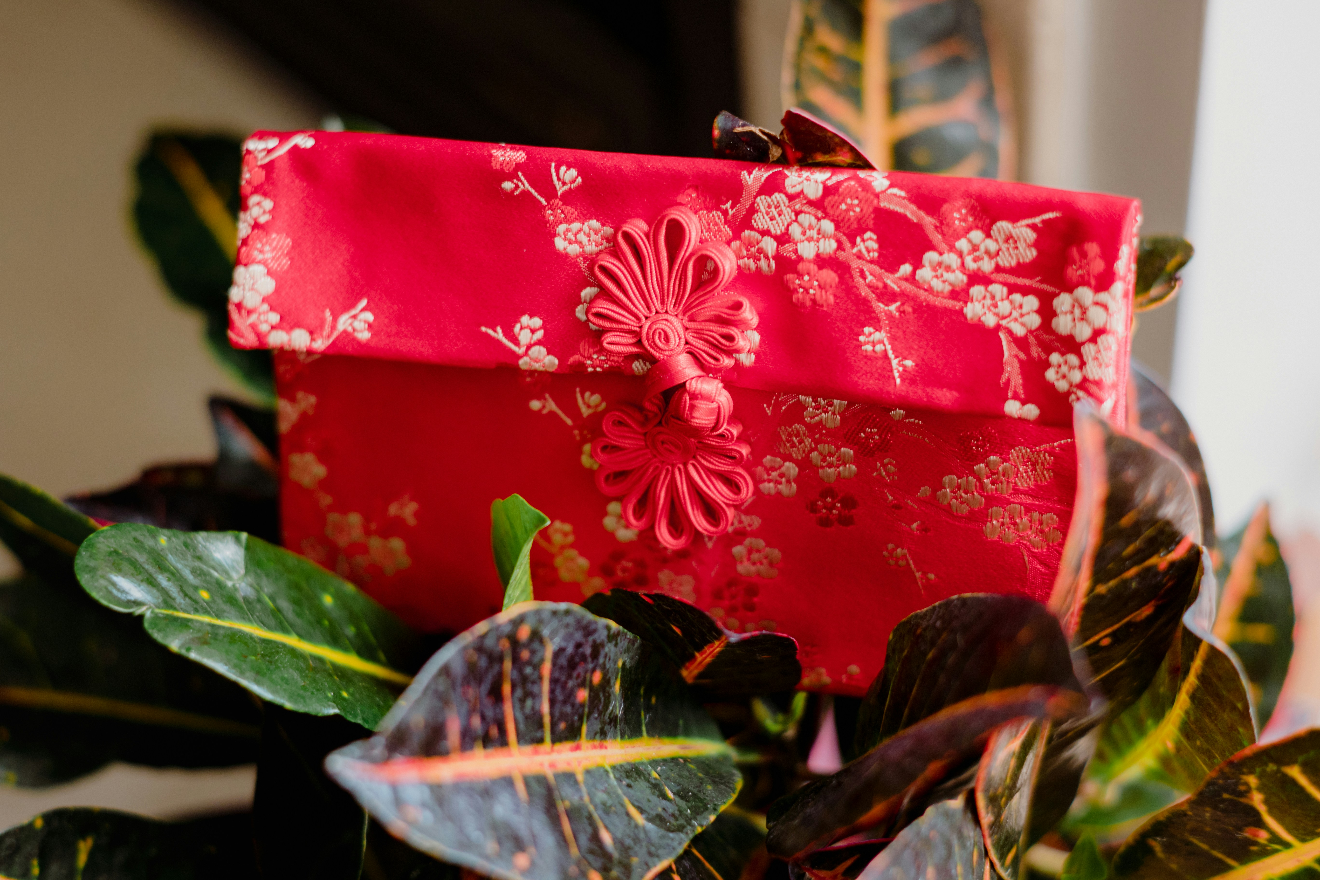 Red Silk Charm: A Tiny Lunar Gift Nestled in Velvet Leaves