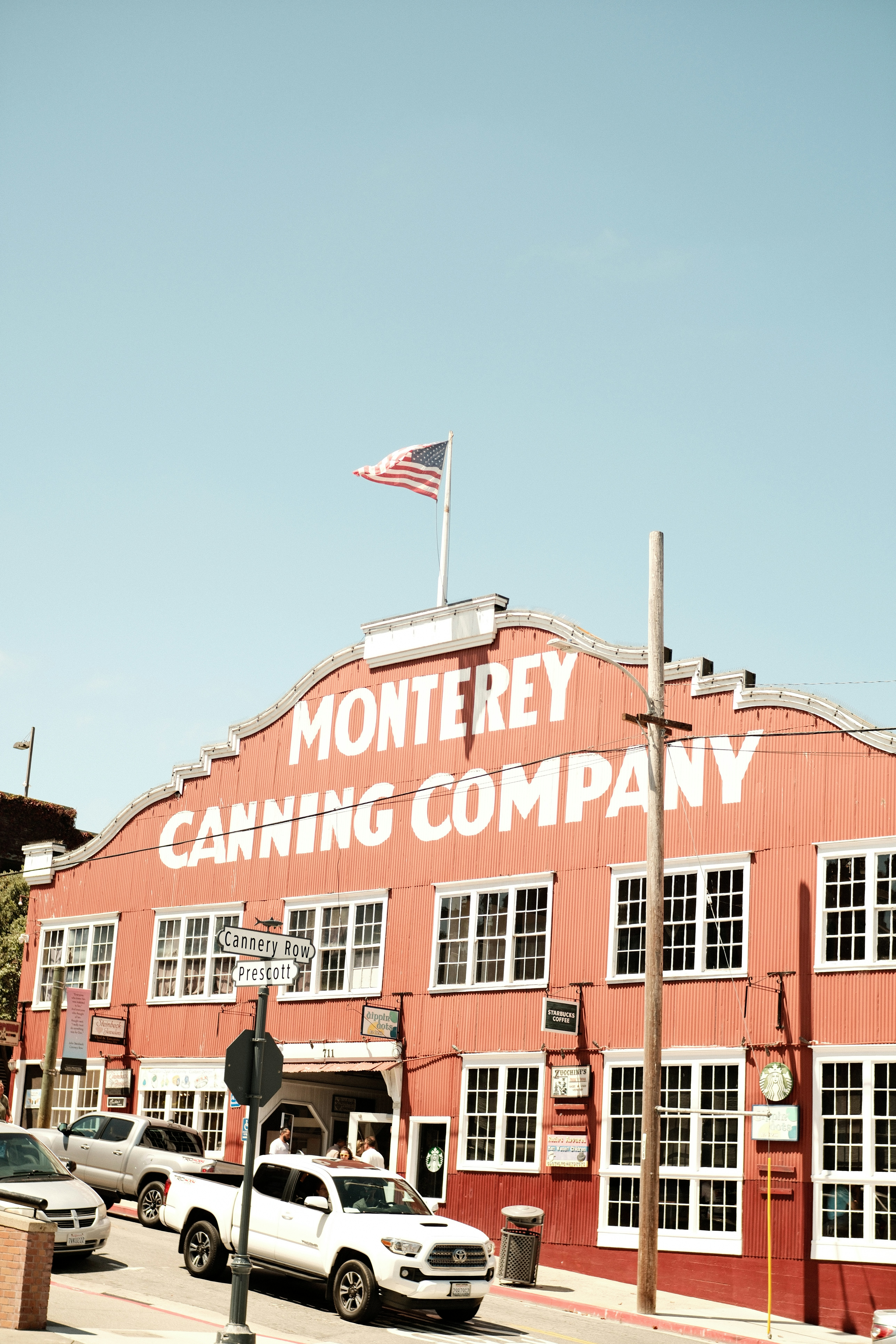 Monterey Canning Company: Sunlit Red Facade Framing a Quiet Street Scene