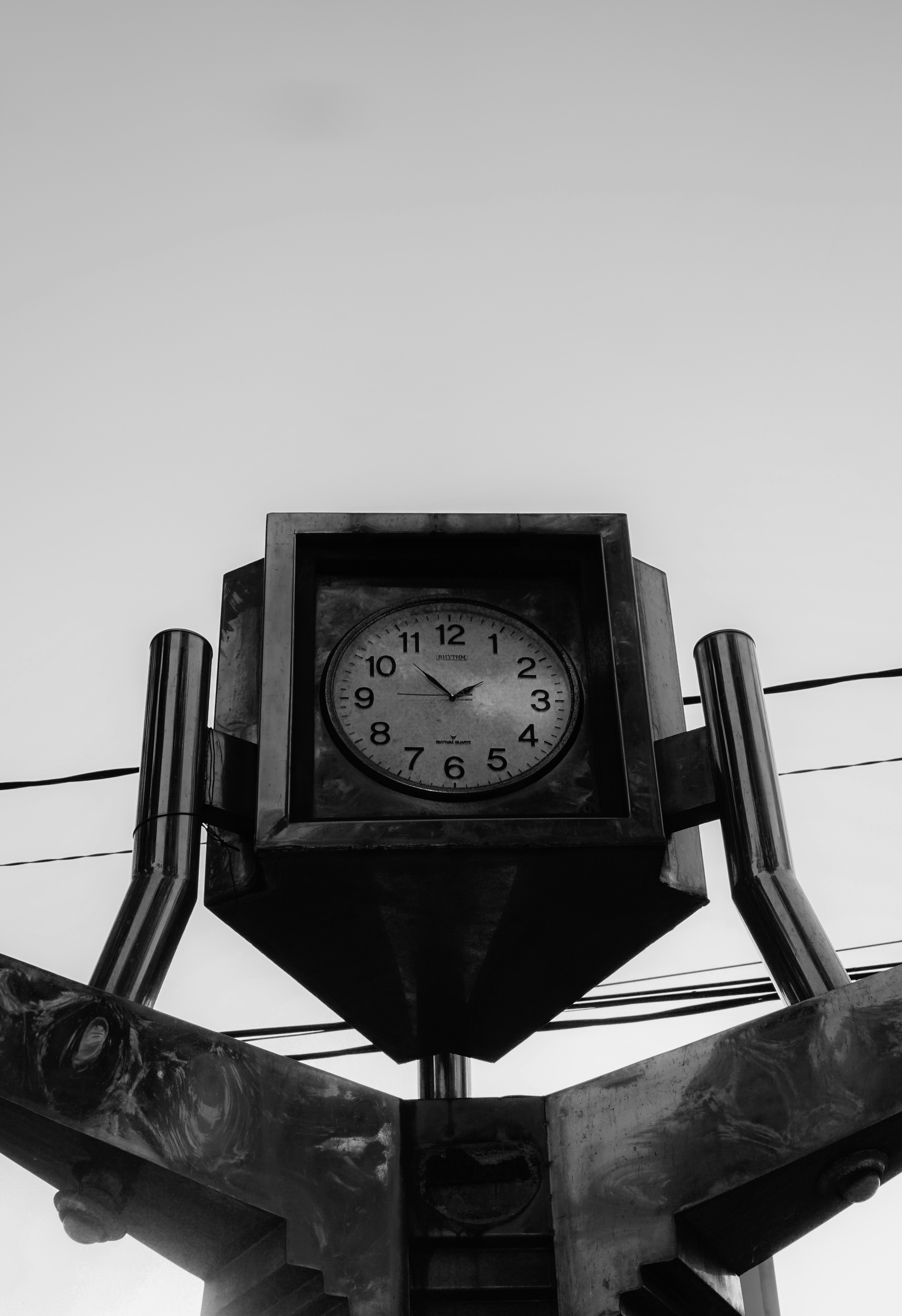 Weathered Clock Crowned by Industrial Rigging in Monochrome