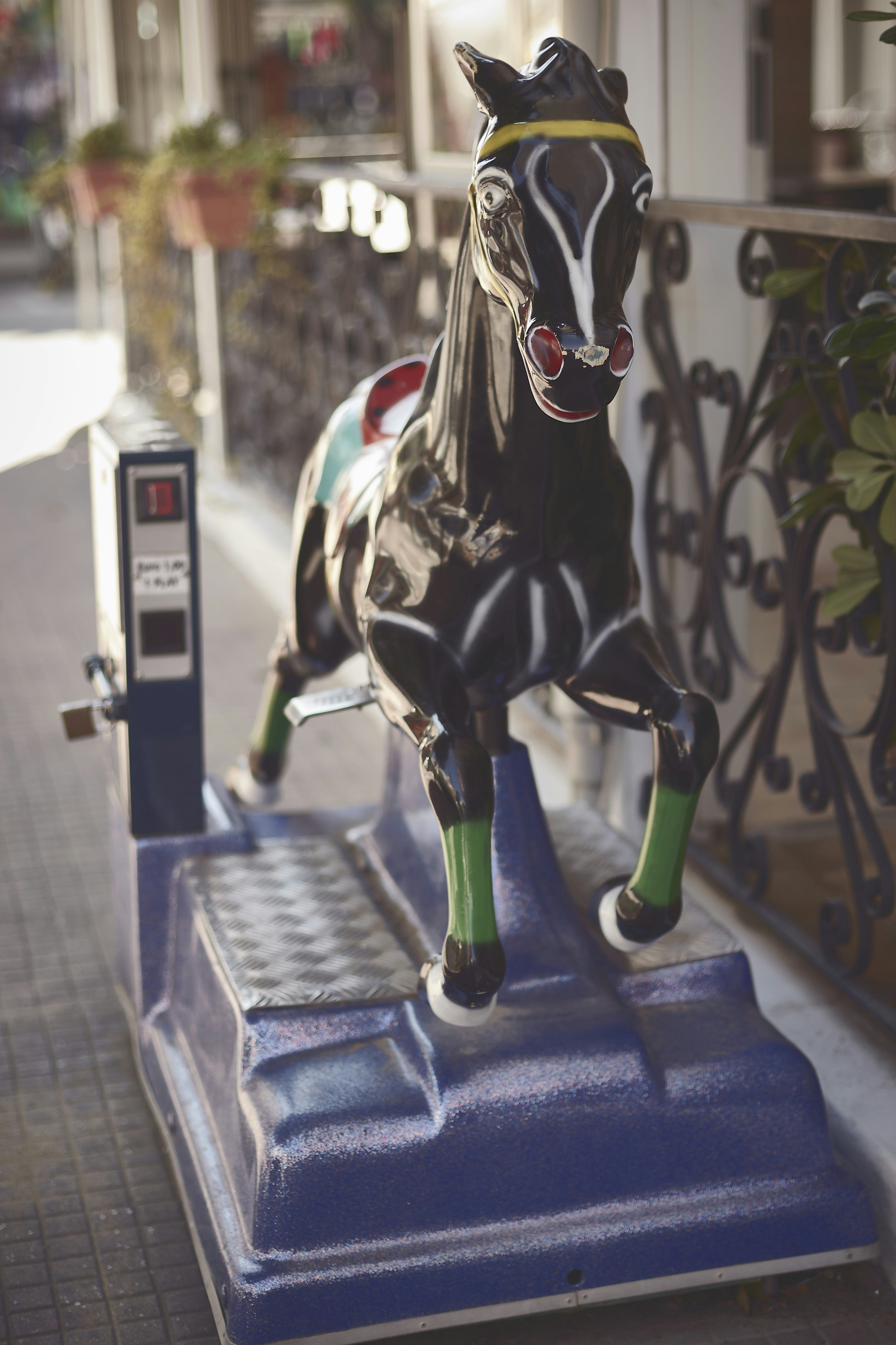 Urban Carousel Horse: Gleaming Black Mare on a Blue Pedestal